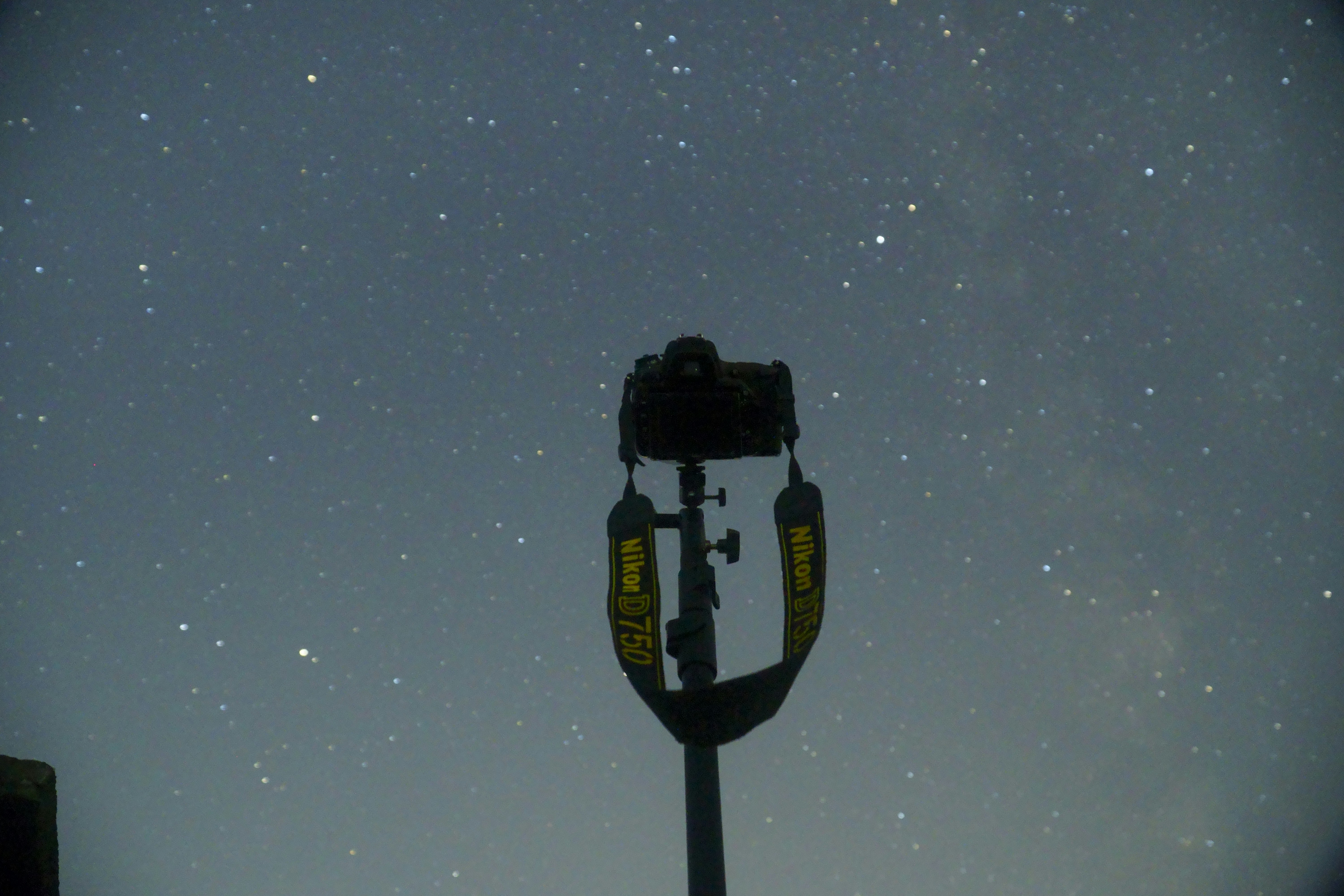 Silhouette of a lone camera rig under a cobalt starfield