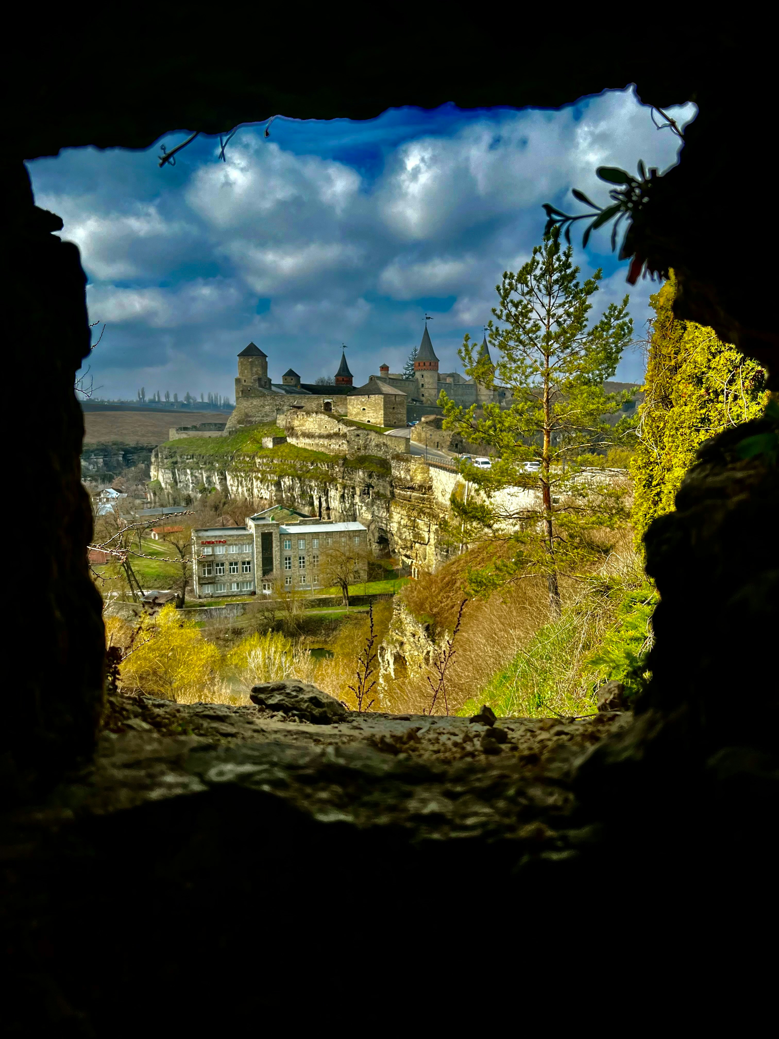 A view of a castle through a hole in a rock photo – Free Кам'янець ...