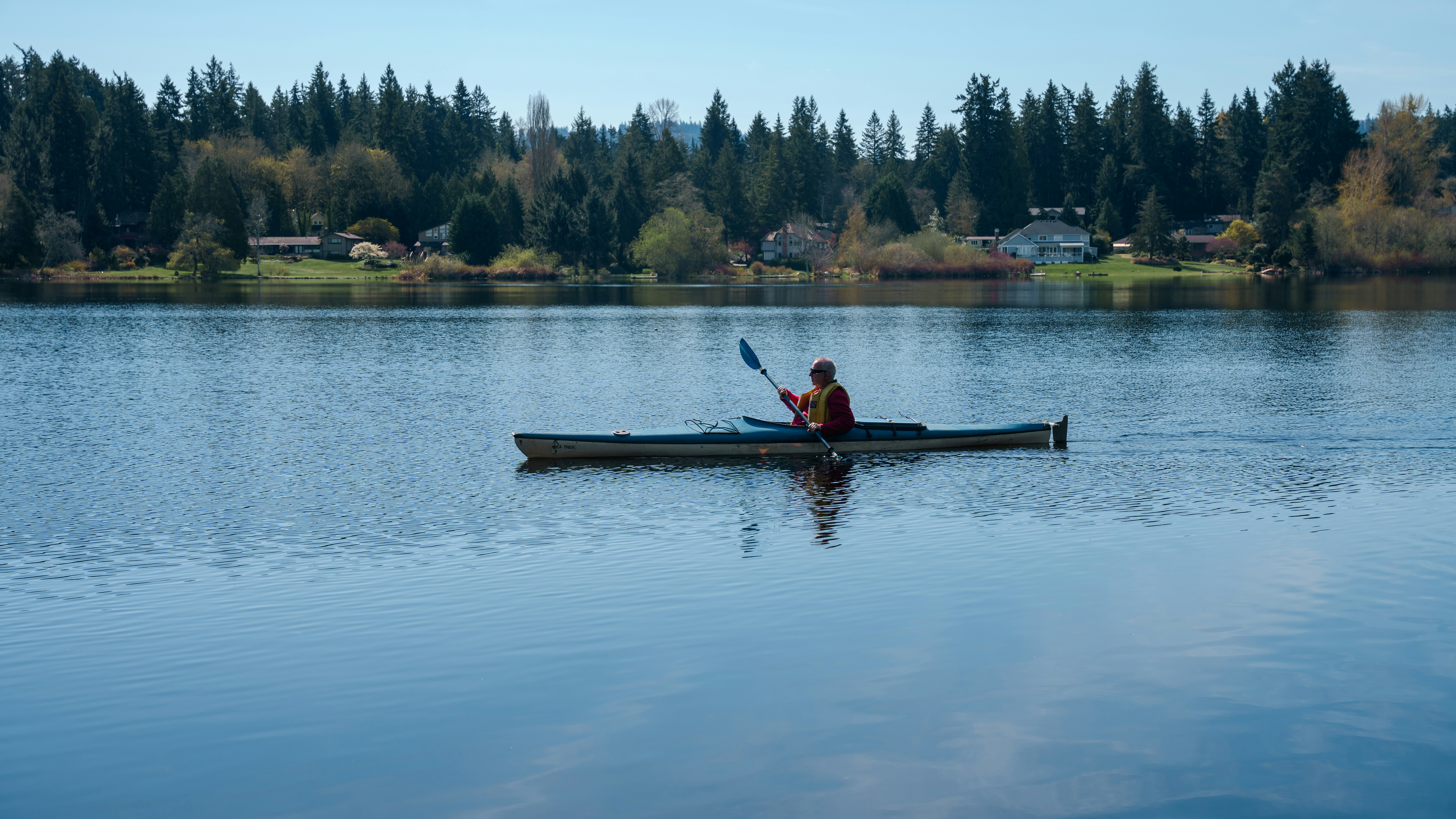 A person in a canoe paddling on a lake photo – Free Human Image on Unsplash