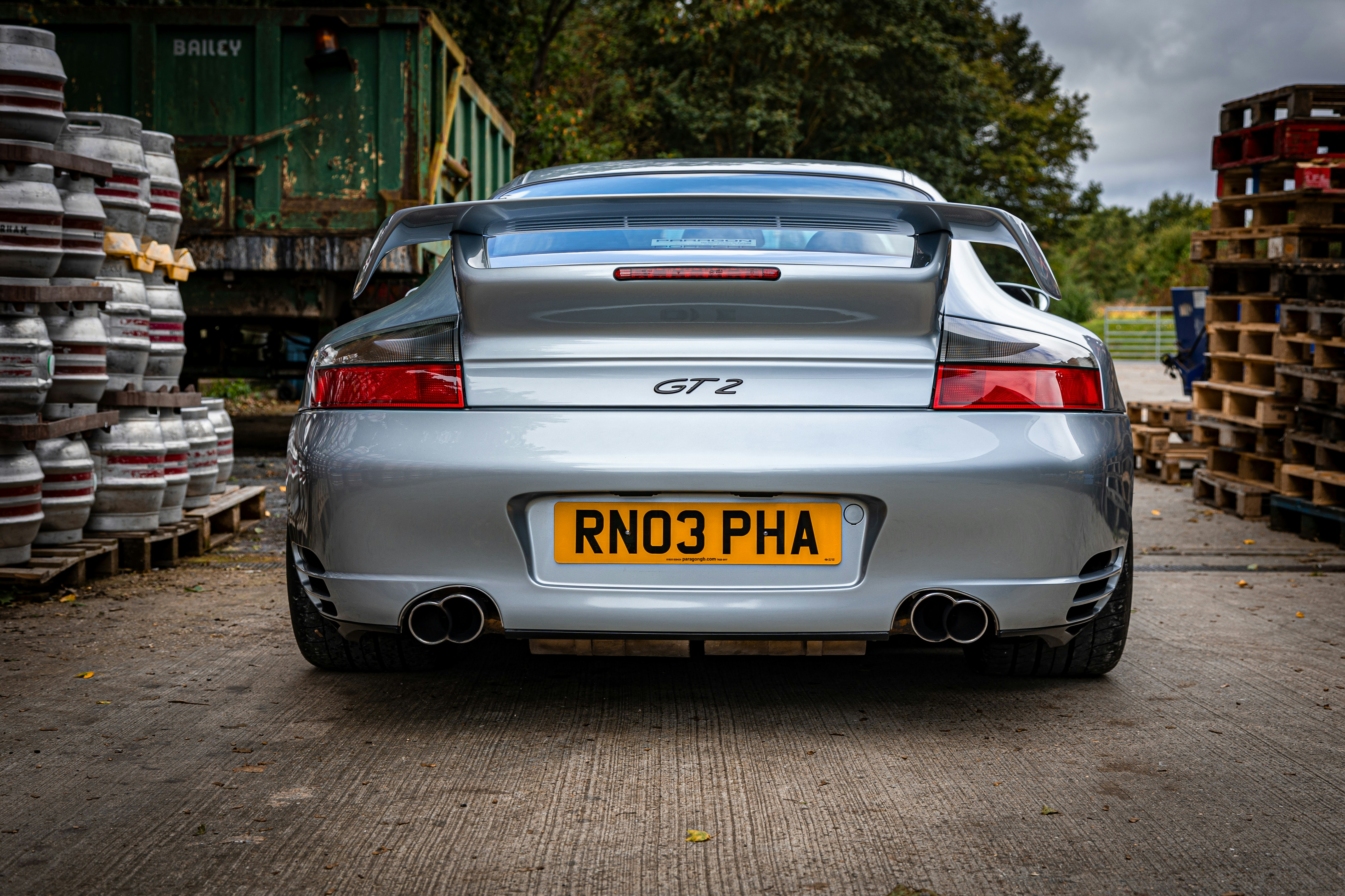 A silver car parked in front of stacks of wood photo – Free Porsche gt2 ...
