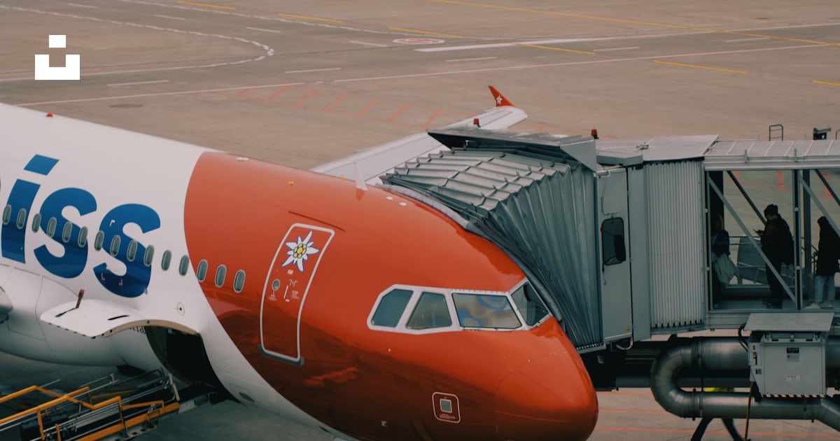 빨간색과 흰색의 비행기가 공항에 주차되어 있습니다 사진 Unsplash의 무료 취리히 공항 Zrh 이미지