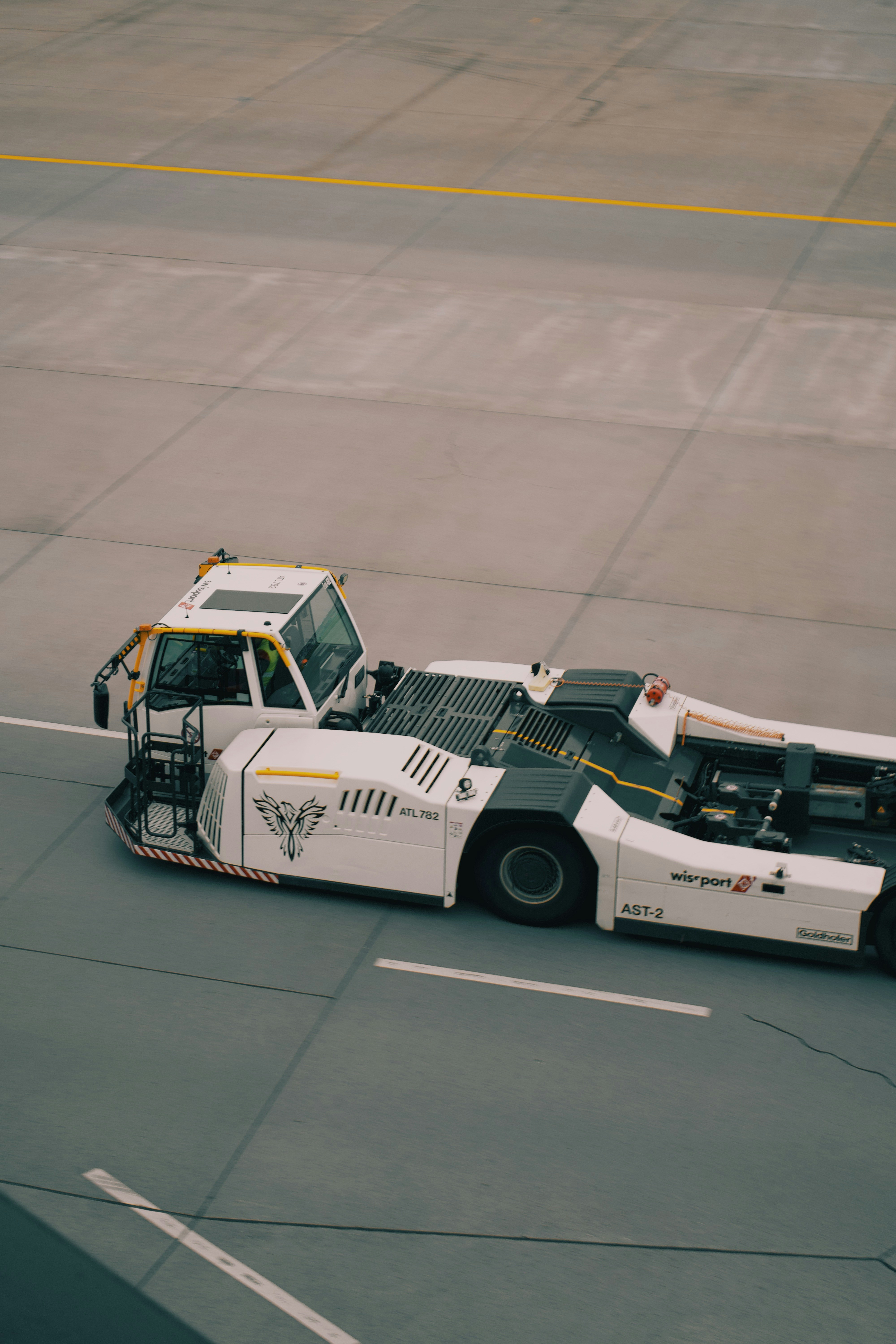 a tow truck driving down an airport runway