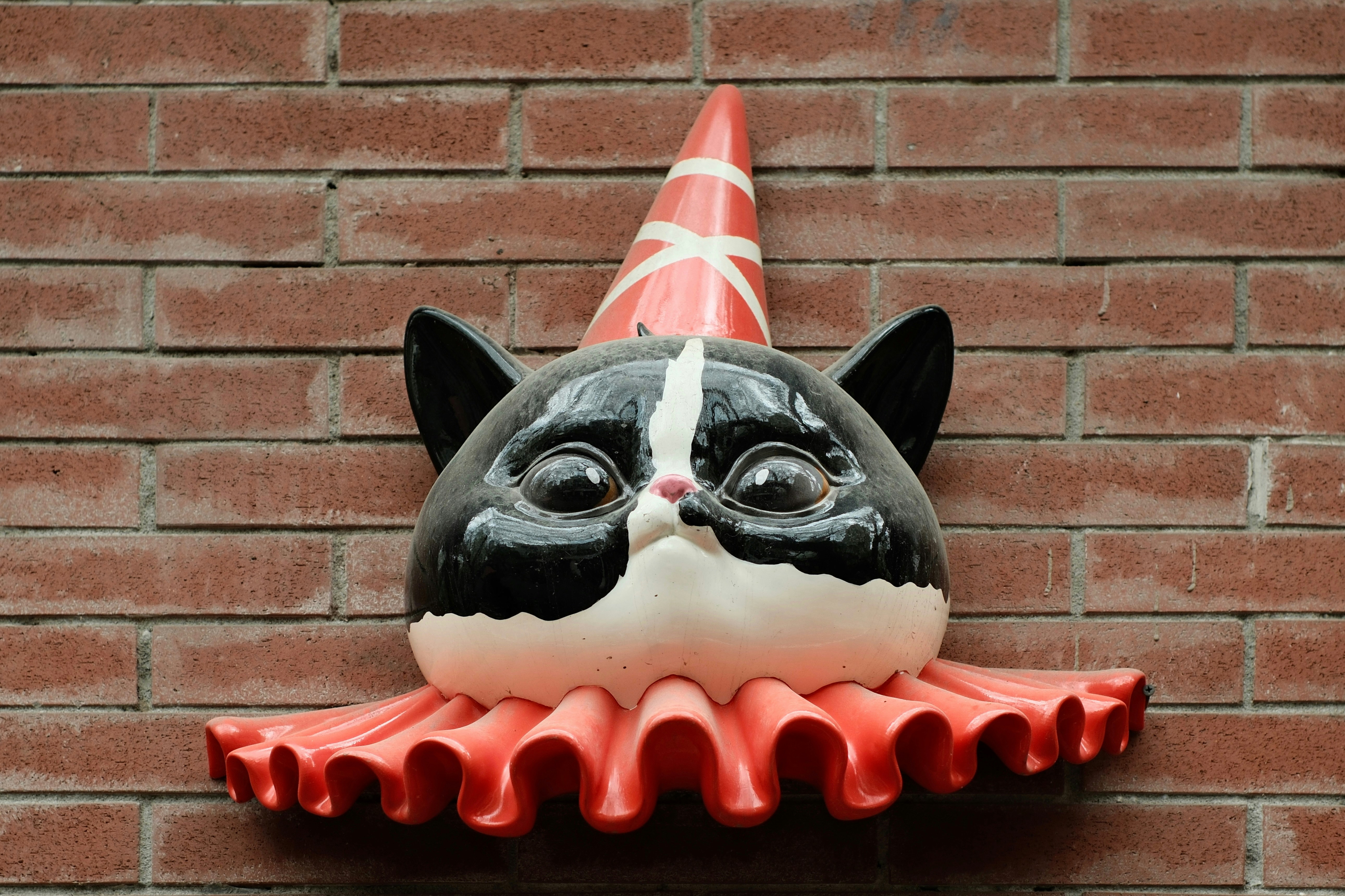 Carnival Cat Head Adorns the Brick Wall with a Red Ruffle Collar