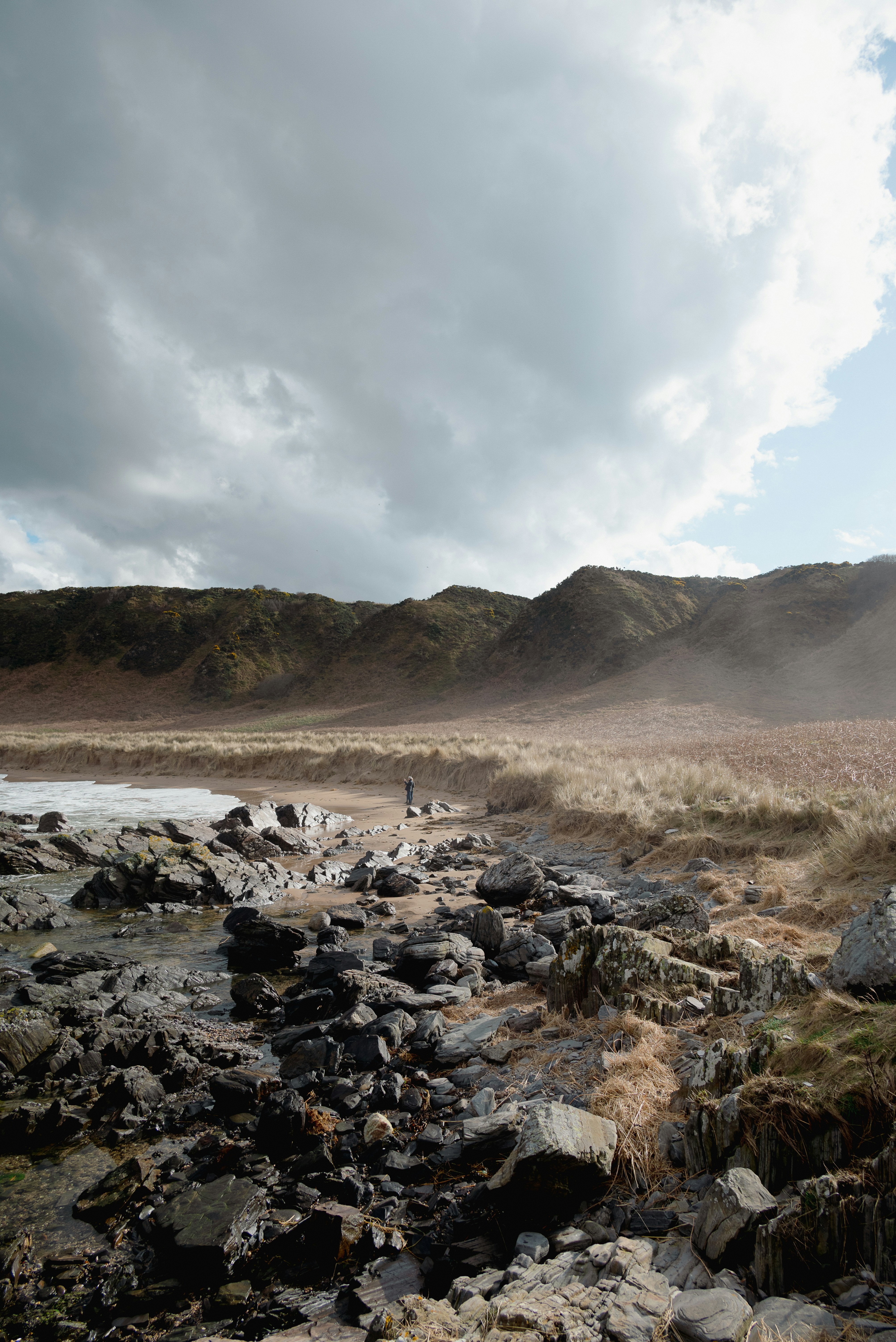 a rocky beach with a body of water in the distance