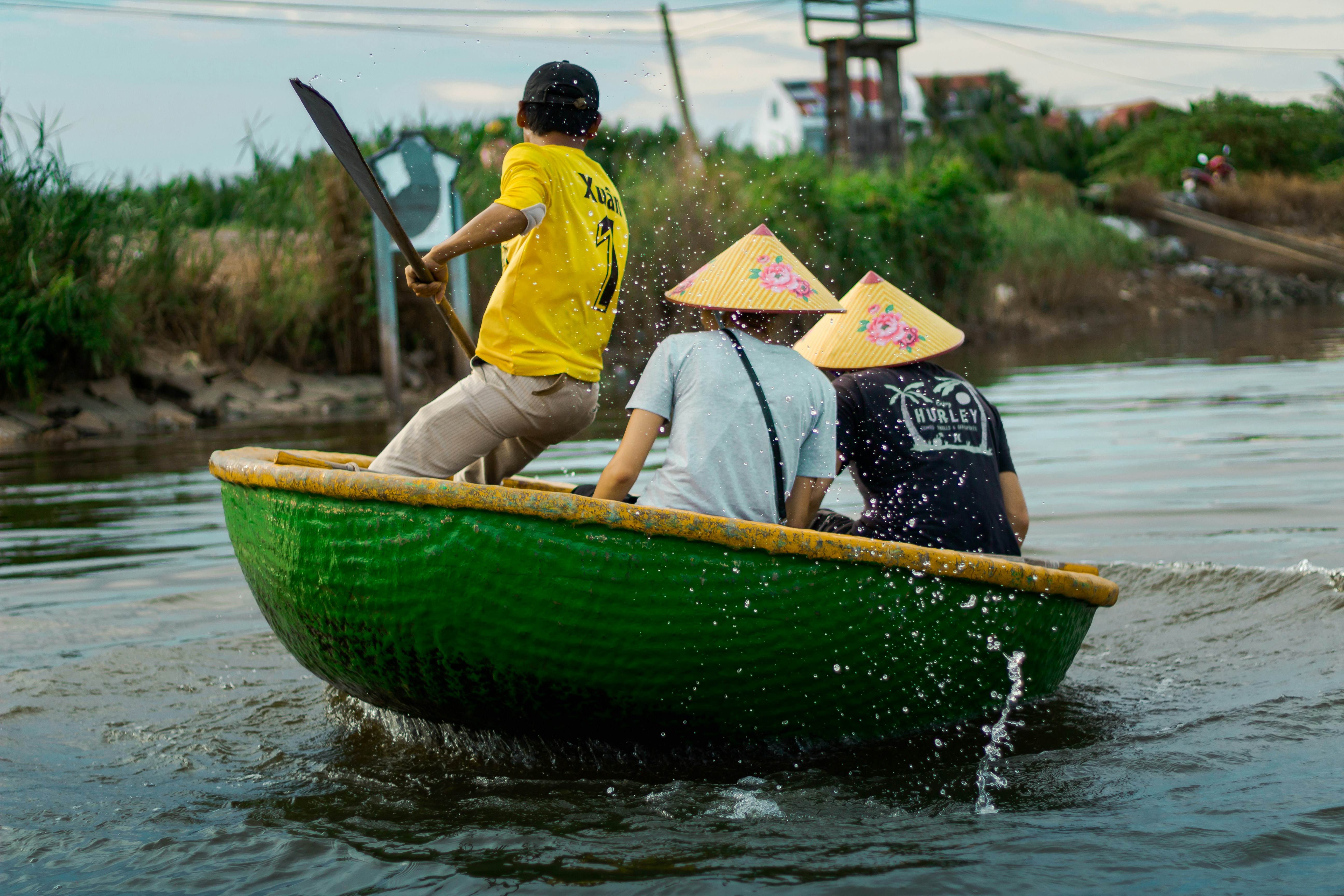 A group of people riding on the back of a green boat photo – Free Woman ...