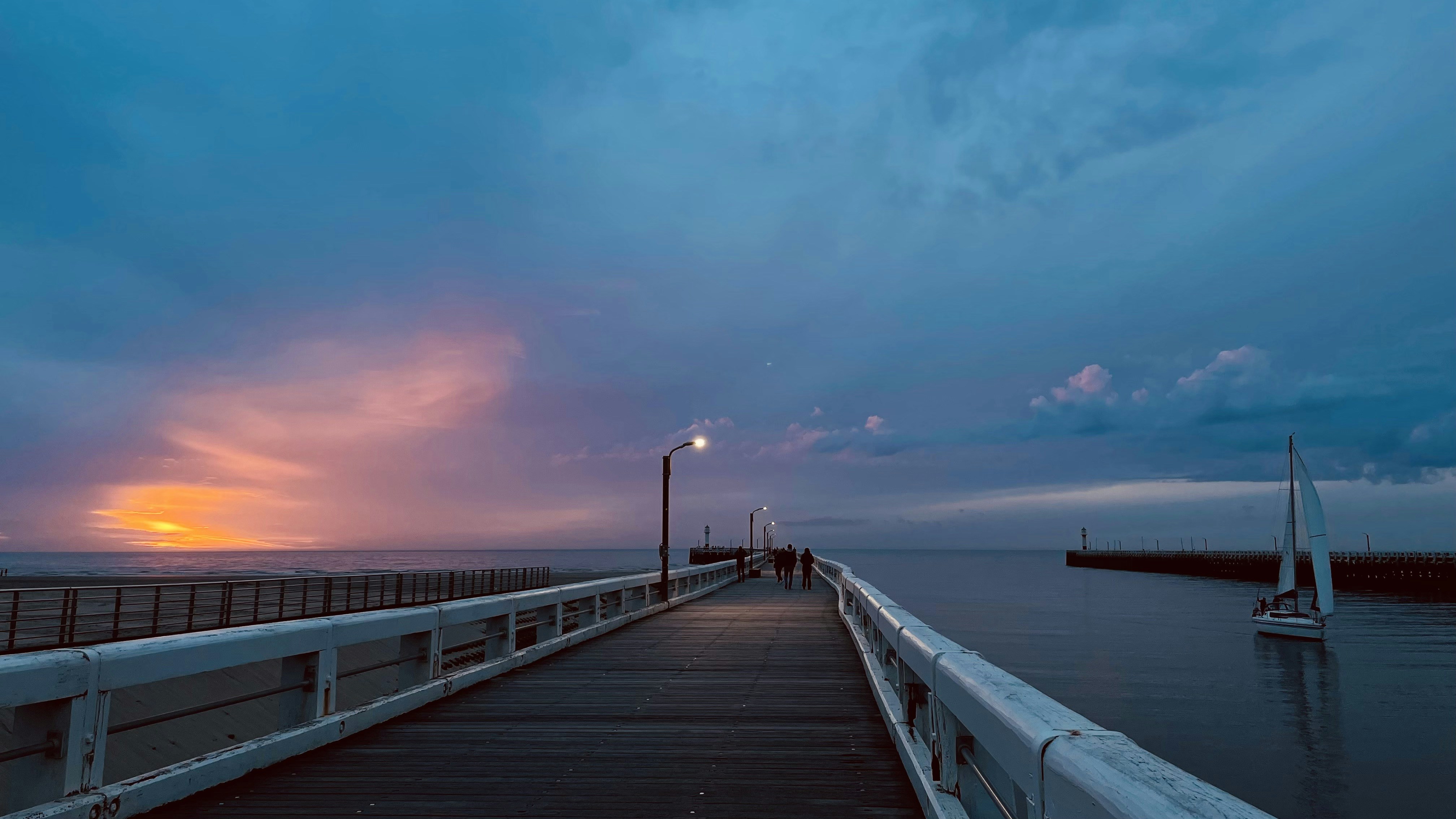 Une jetée avec un lampadaire et des voiliers dans l’eau photo – Photo ...