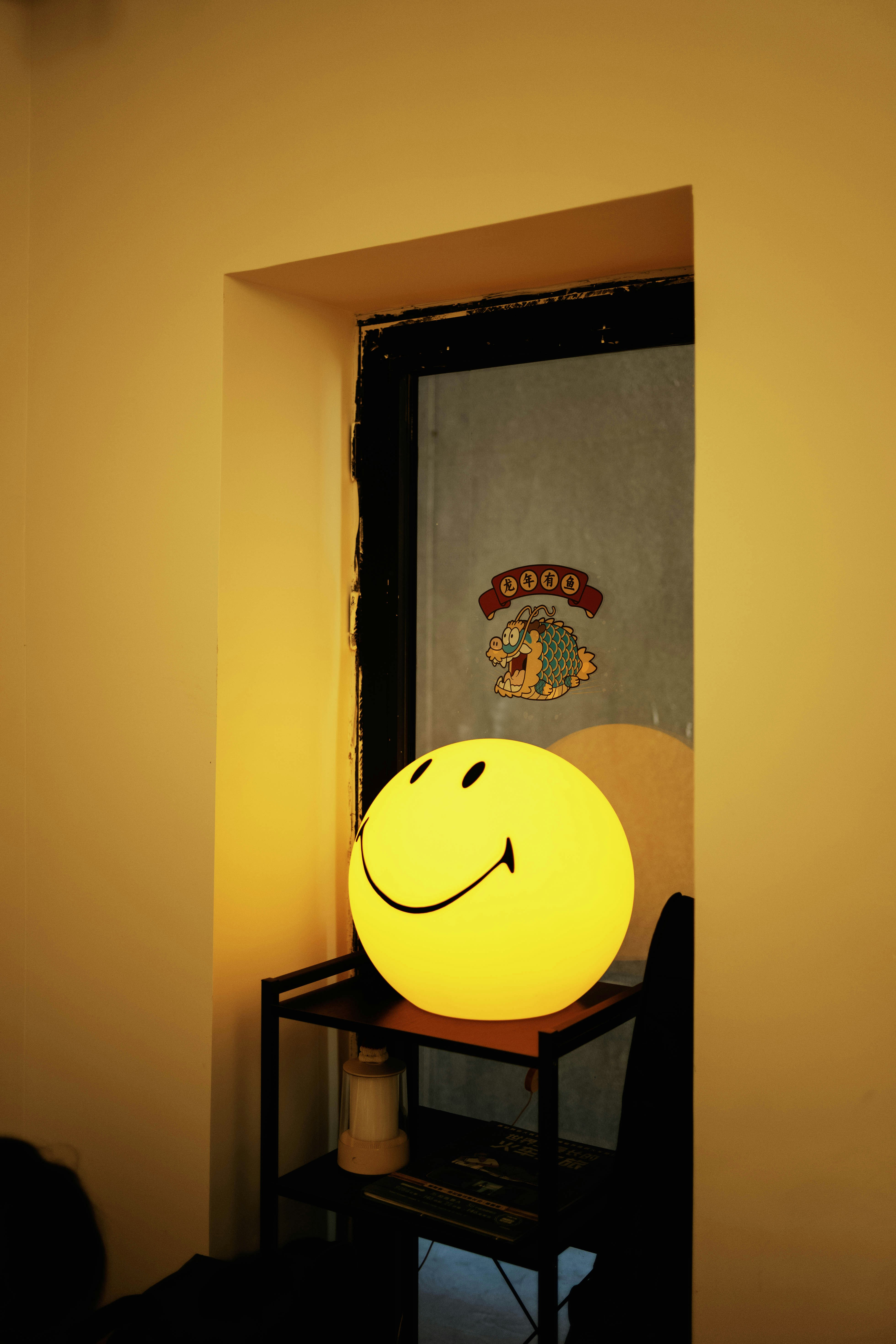 A smiley face lamp sitting on top of a table photo – Free Woman Image ...