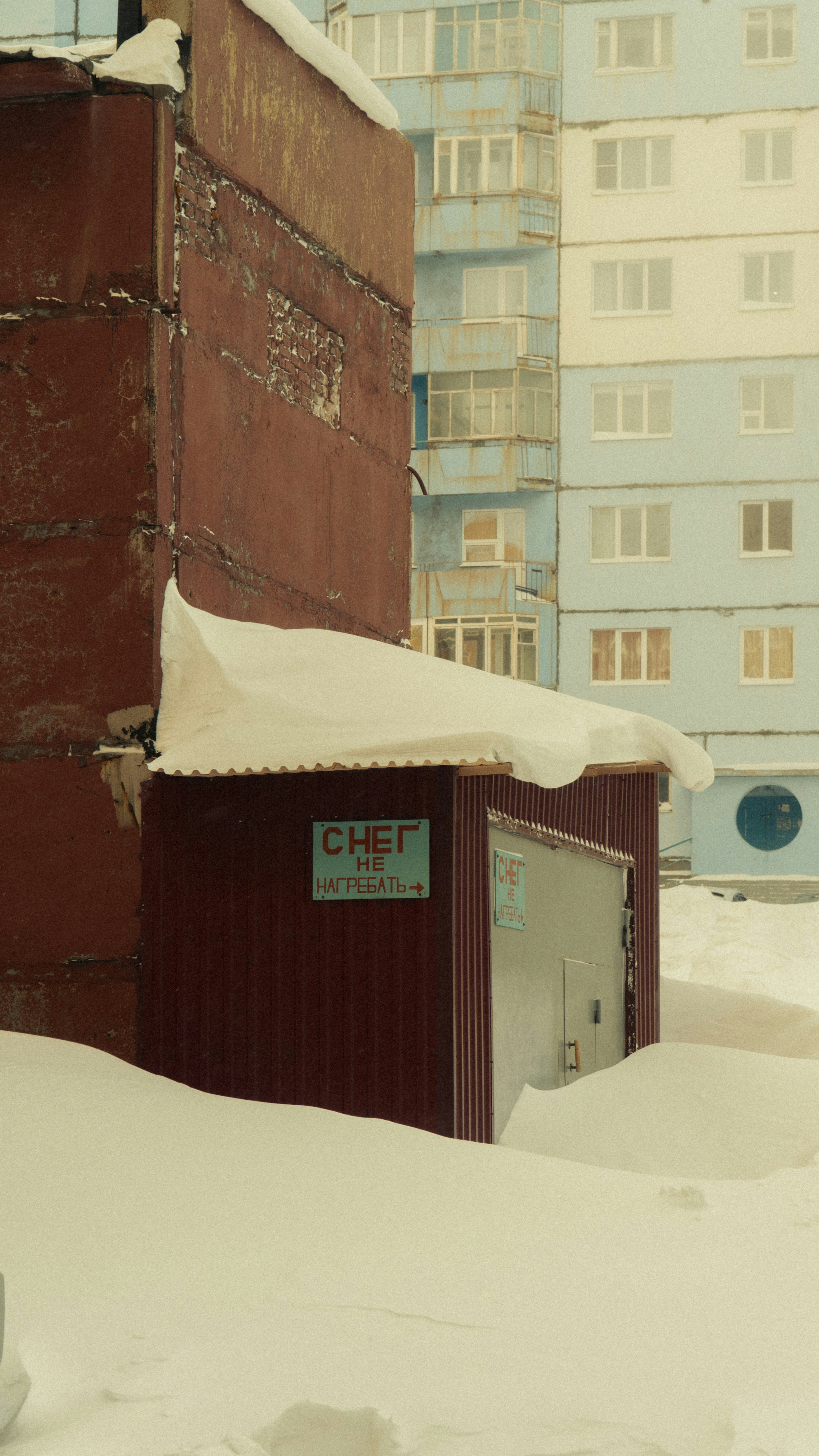 Snow-Crowned Red Shed Anchors a Quiet City Block
