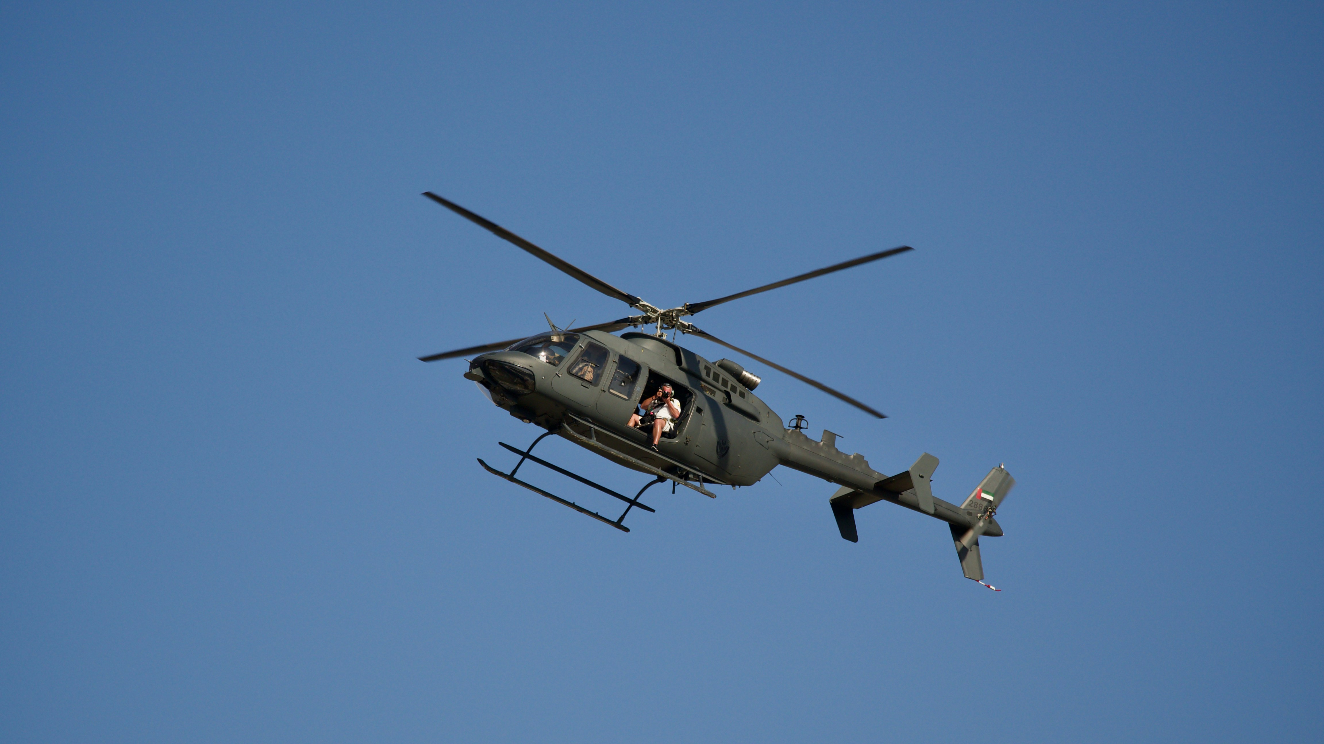 Un helicóptero militar volando a través de un cielo azul foto – Imagen ...