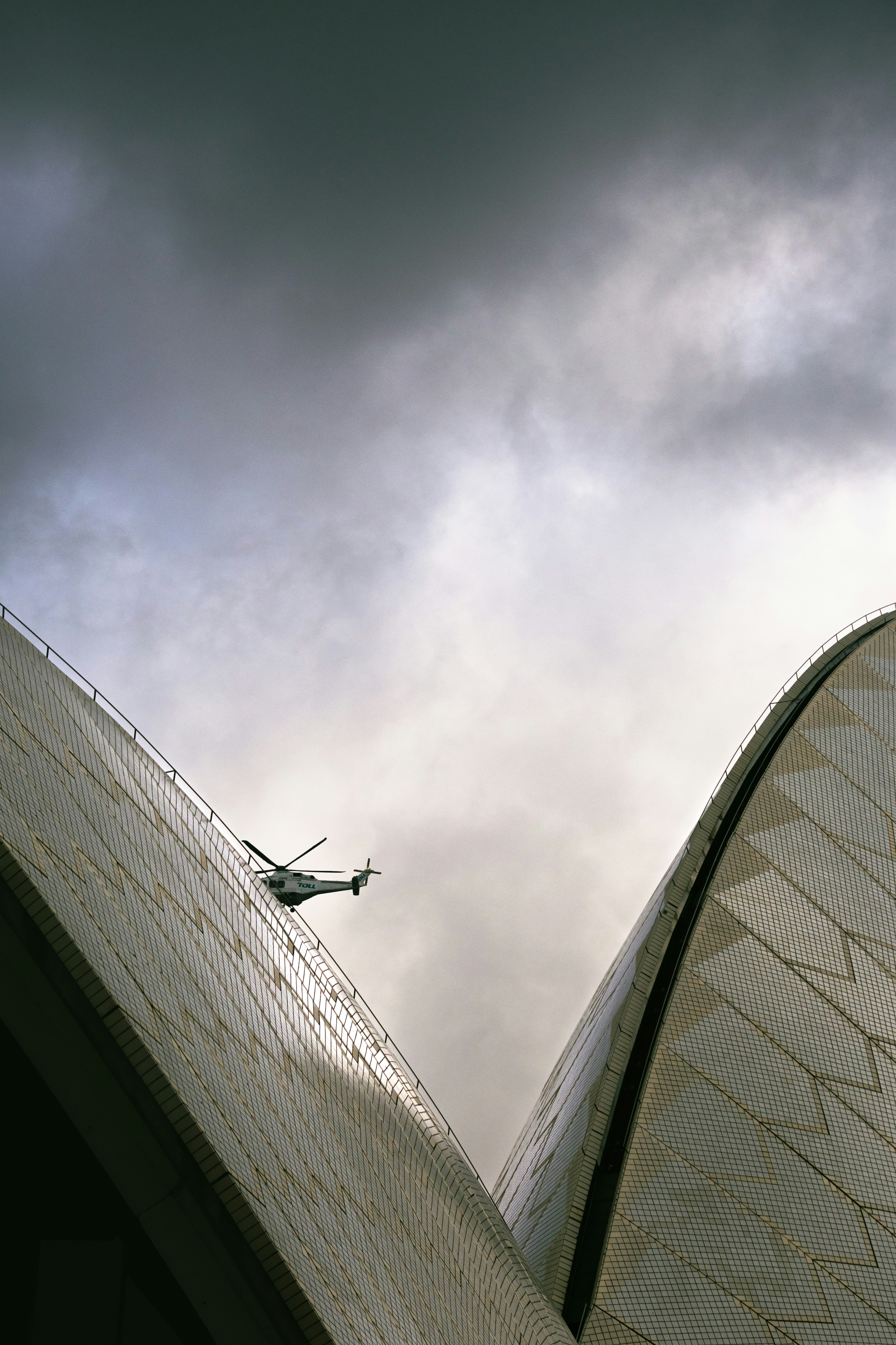 Midair Between Sails: Helicopter Navigates the Gap Between Curved Facades