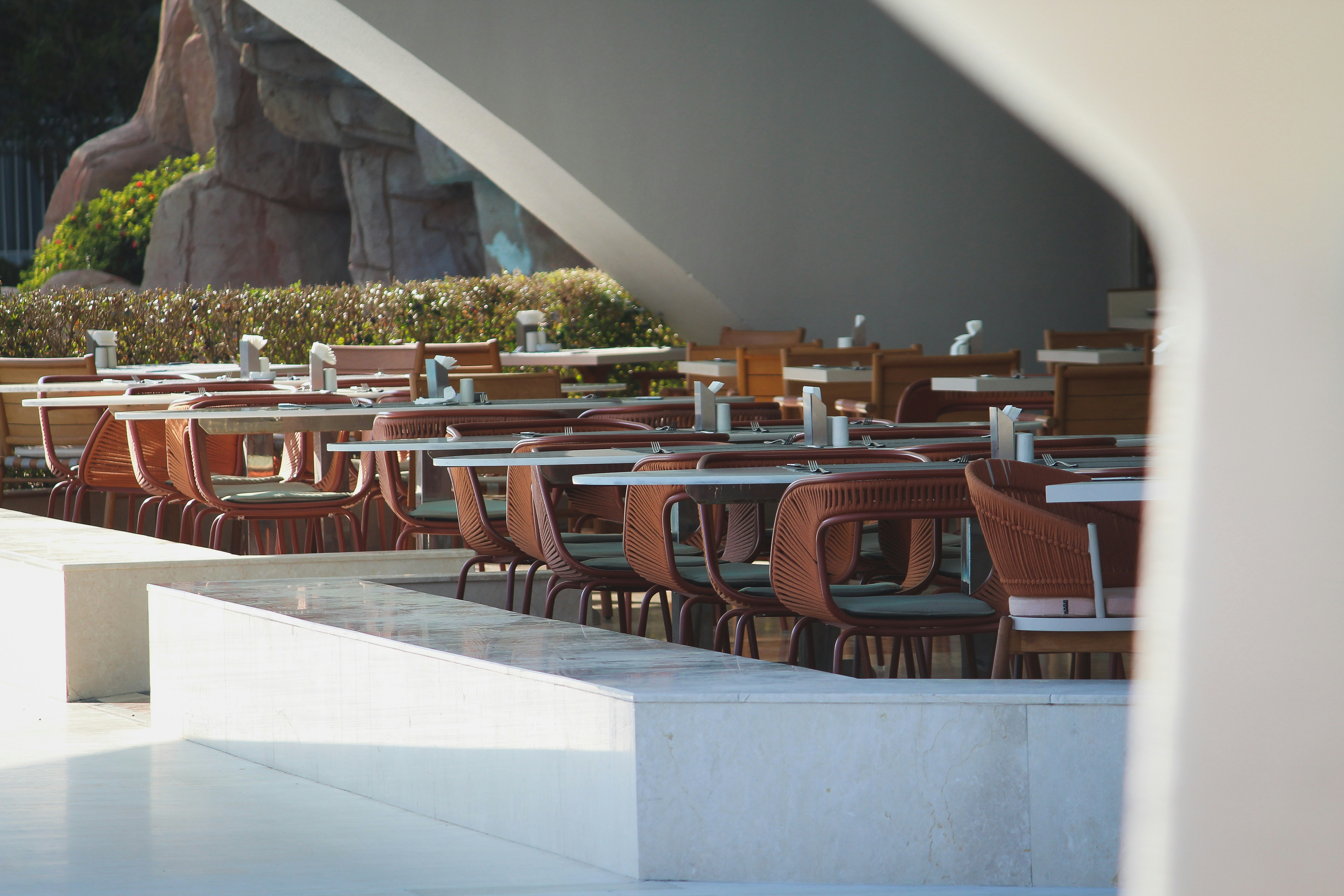 Shadowed Terrace: A Quiet Cafe Behind Arched Architecture
