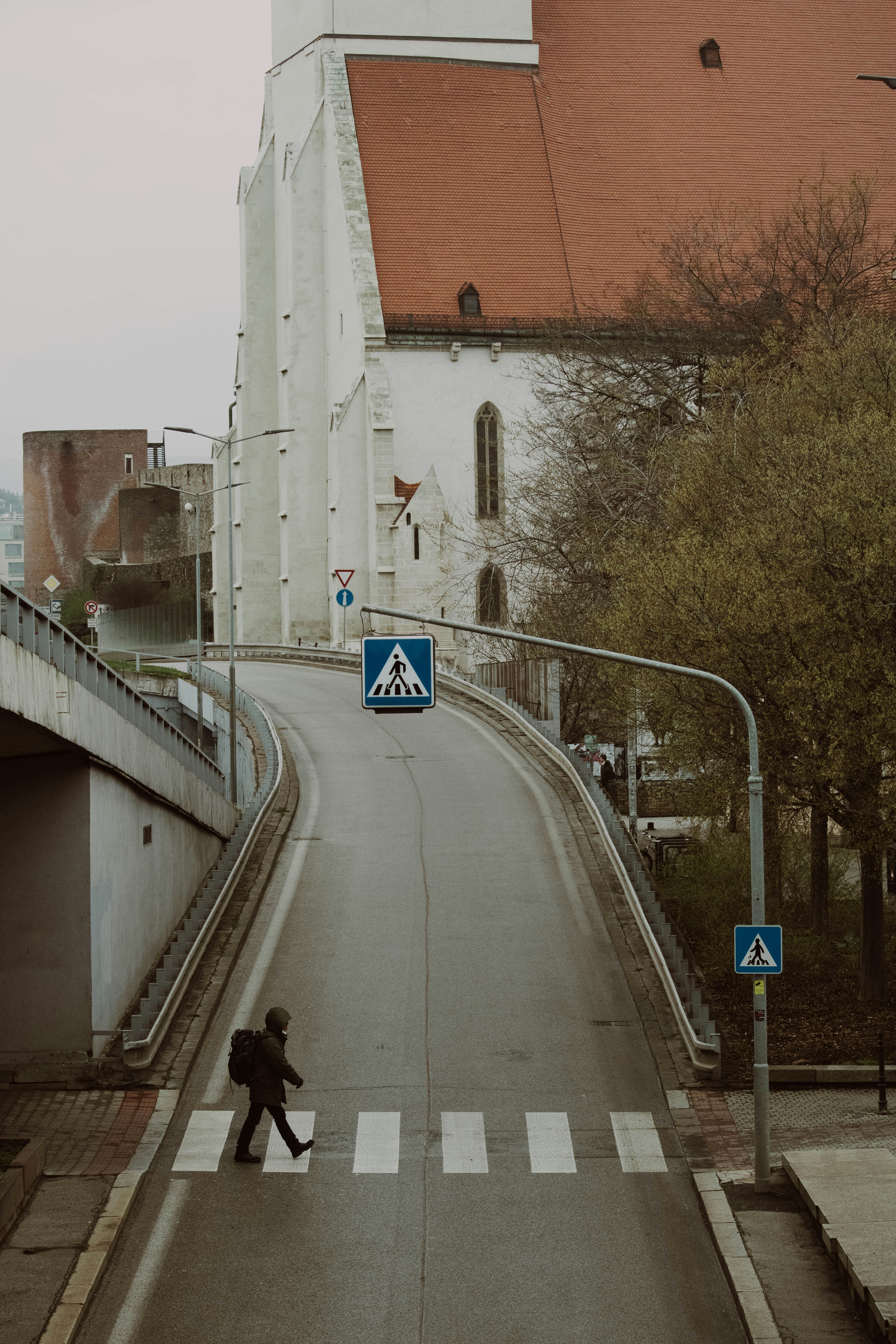 Crossing the Curve toward a Red-Roofed Church: A Quiet Urban Moment