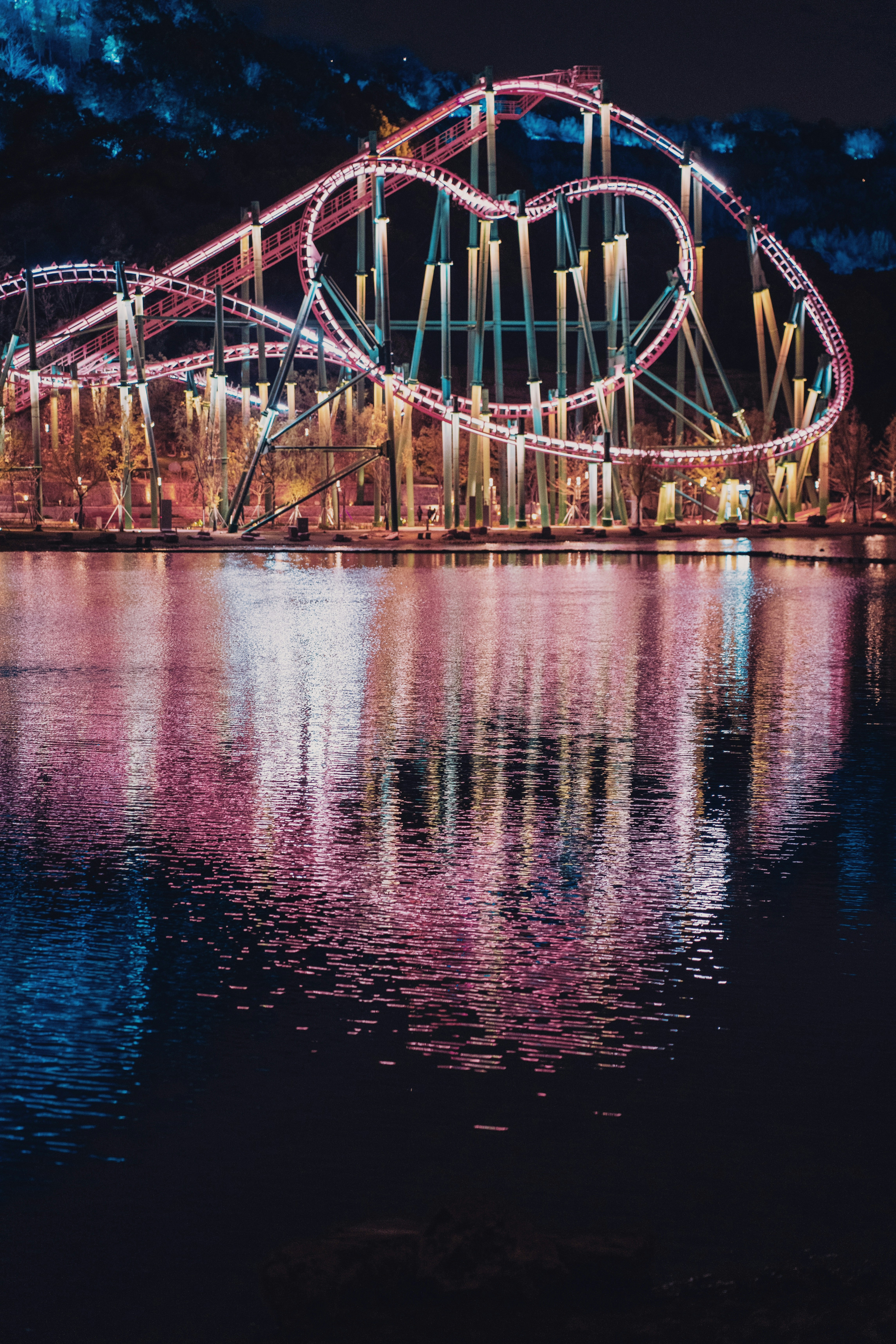 A roller coaster is lit up at night photo – Free Roller coaster Image ...