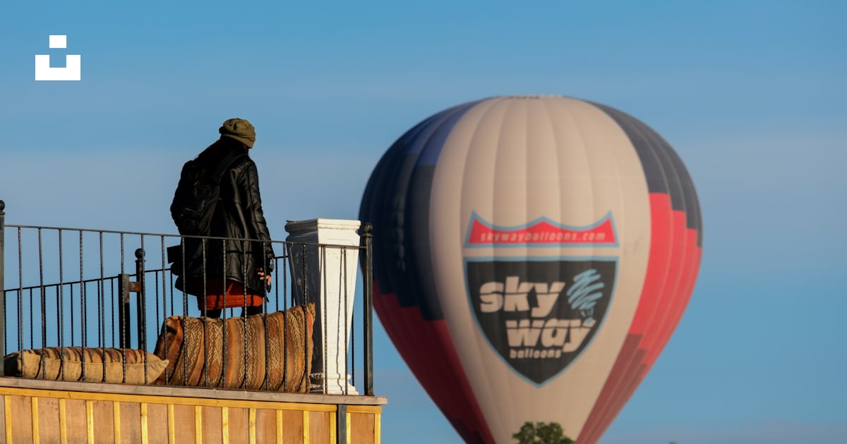 Un Homme Debout Sur Un Balcon à Côté Dune Montgolfière Photo Image