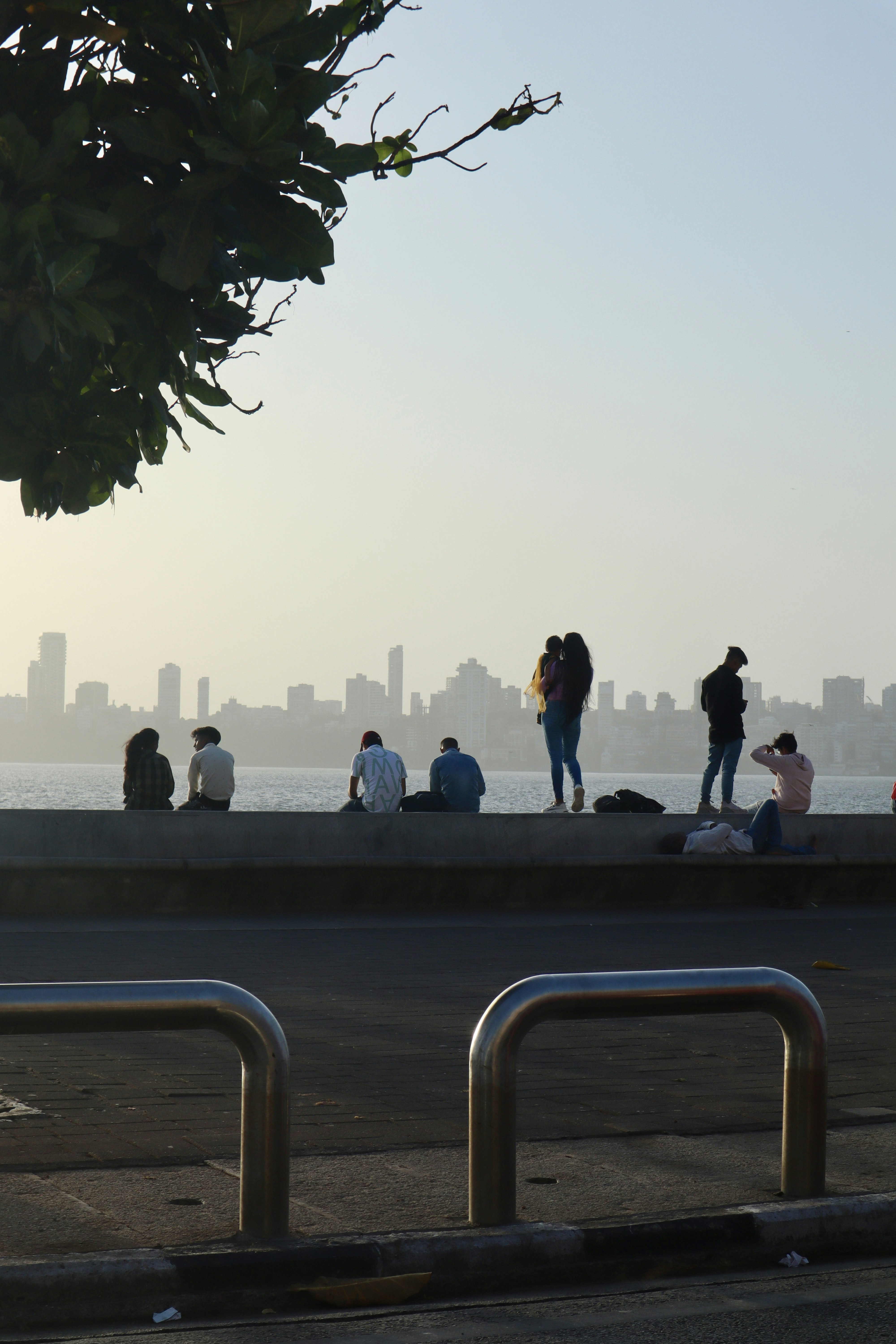 Twilight on the Waterfront: Silhouetted Figures Along a Quiet Seafront