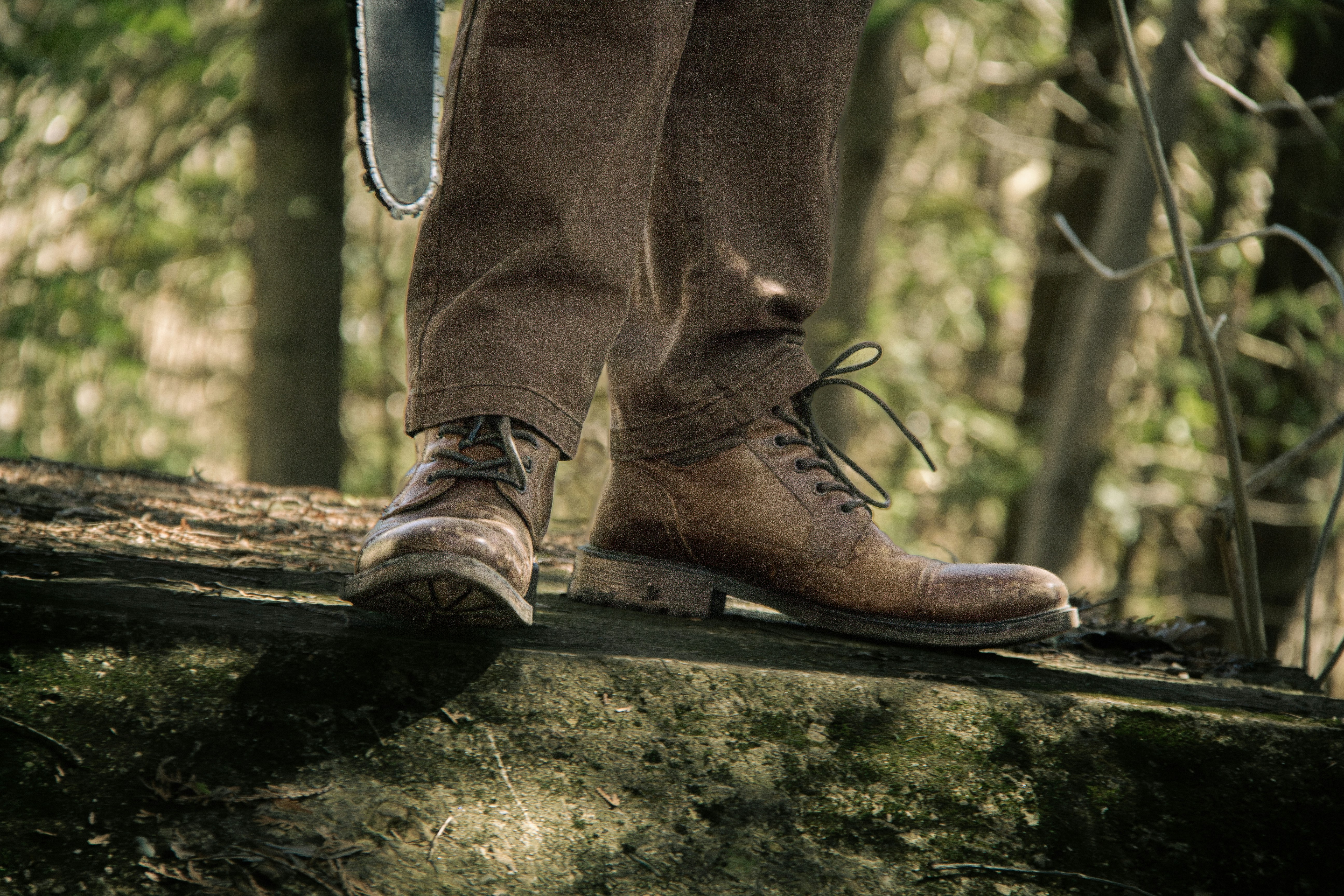 Edge of the Log: A Close-Up of Rugged Boots in a Quiet Forest