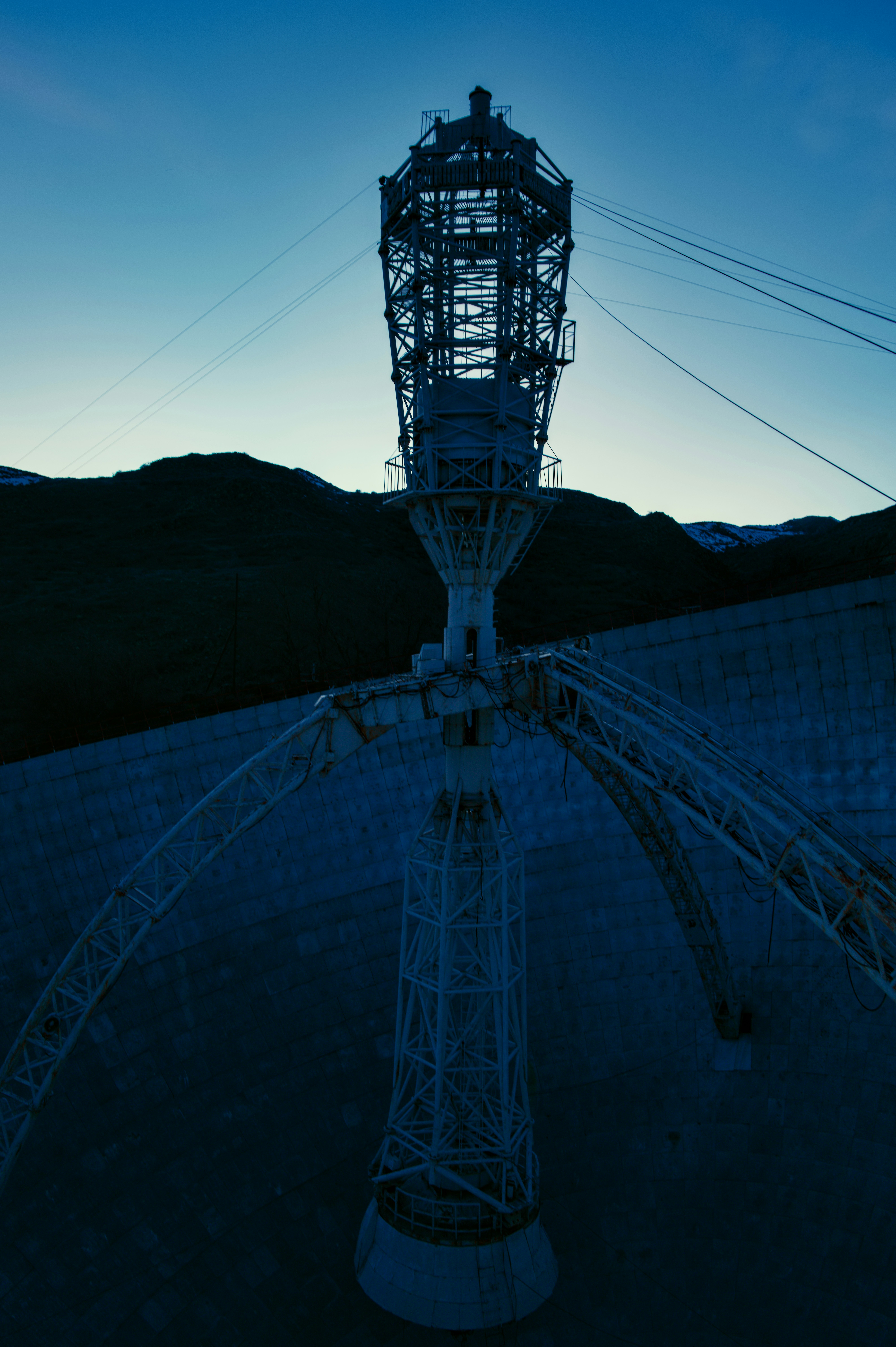 Blue Hour Lattice Sentinel: Tower Rising Over a Curved Dam