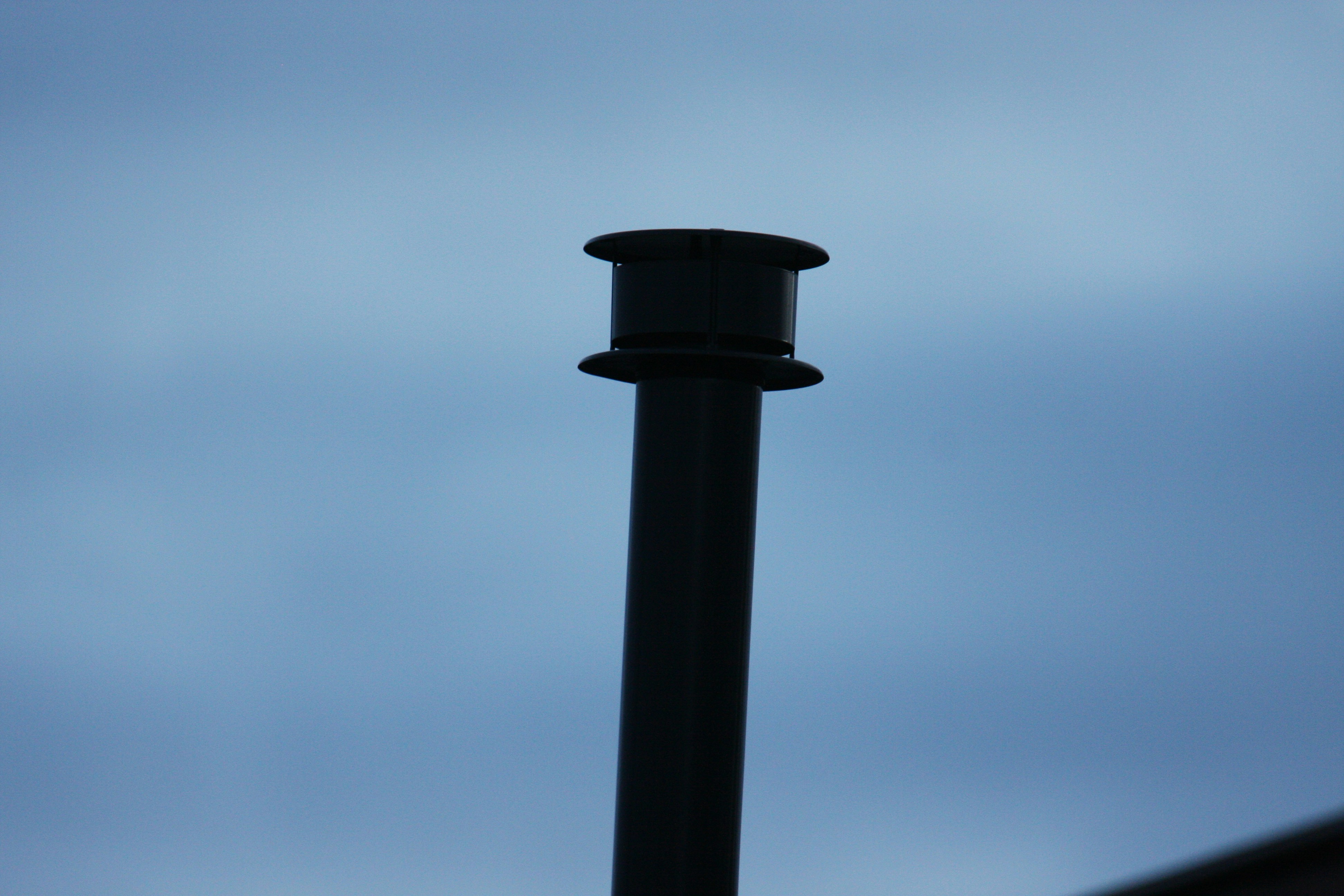 Industrial Chimney Silhouette Reaching Toward a Calm Sky