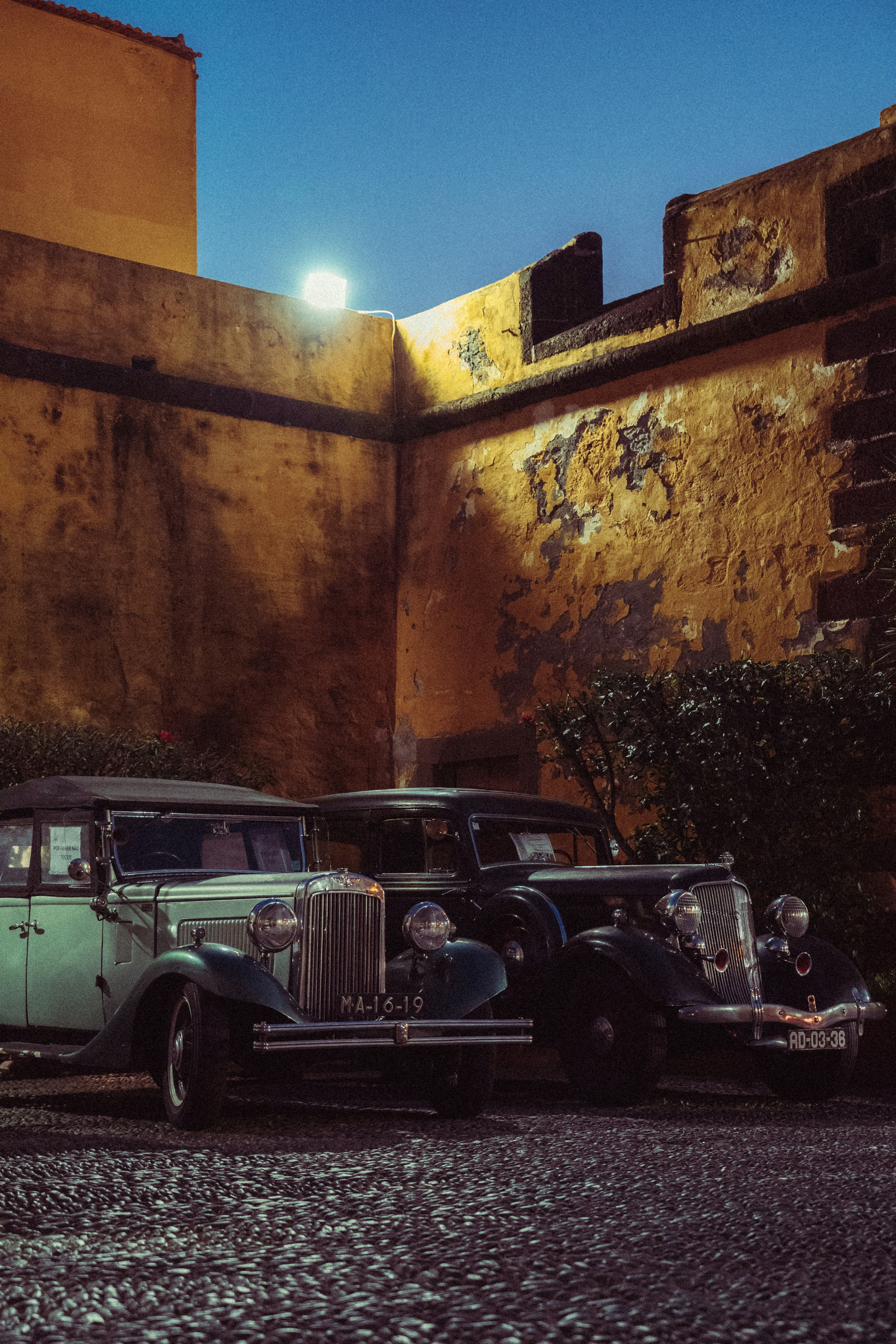 Timeless Rumble: Vintage Cars Rest in a Moonlit Courtyard