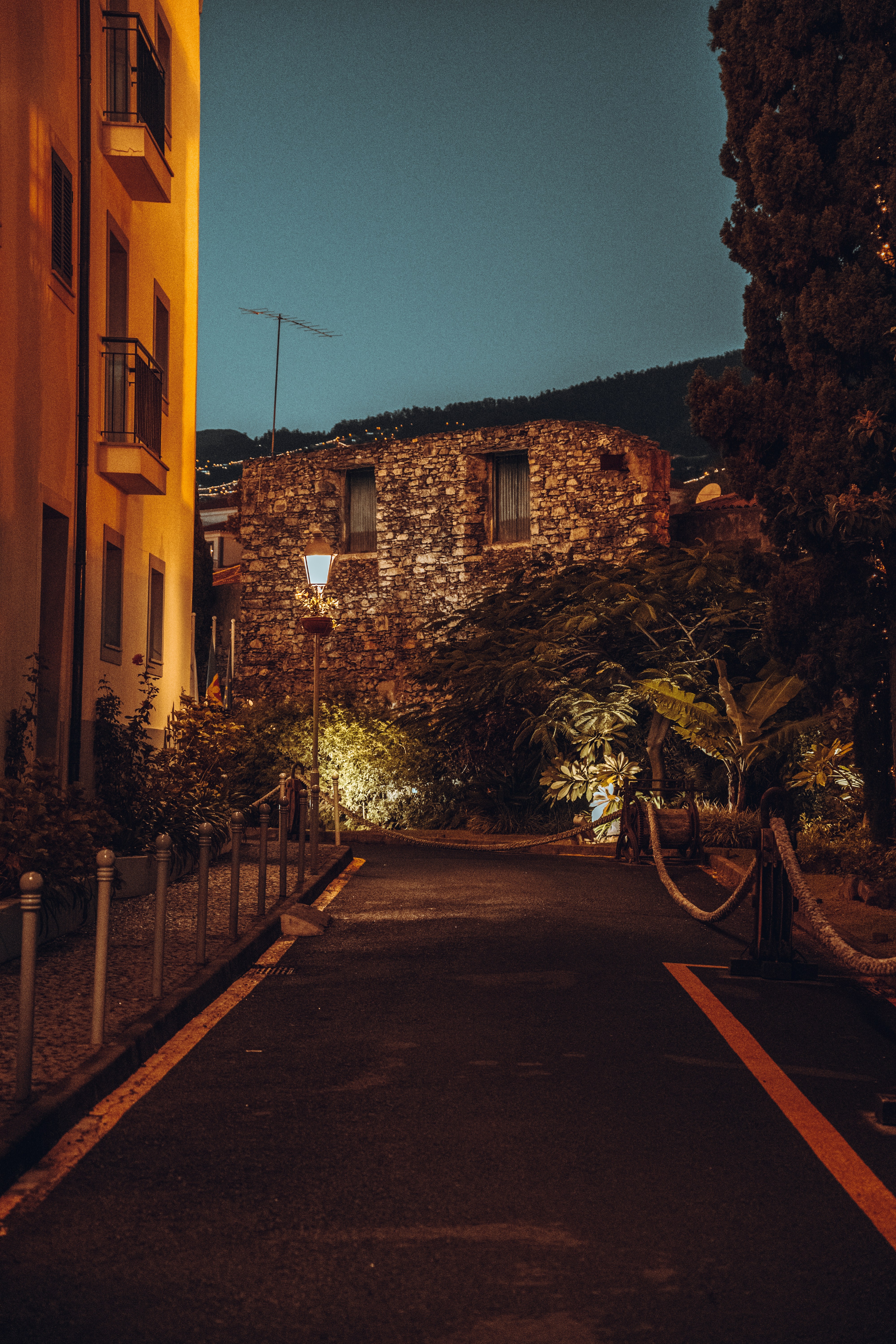 Amber Lantern Over a Stone-Walled Lane: A Quiet Night Walkway
