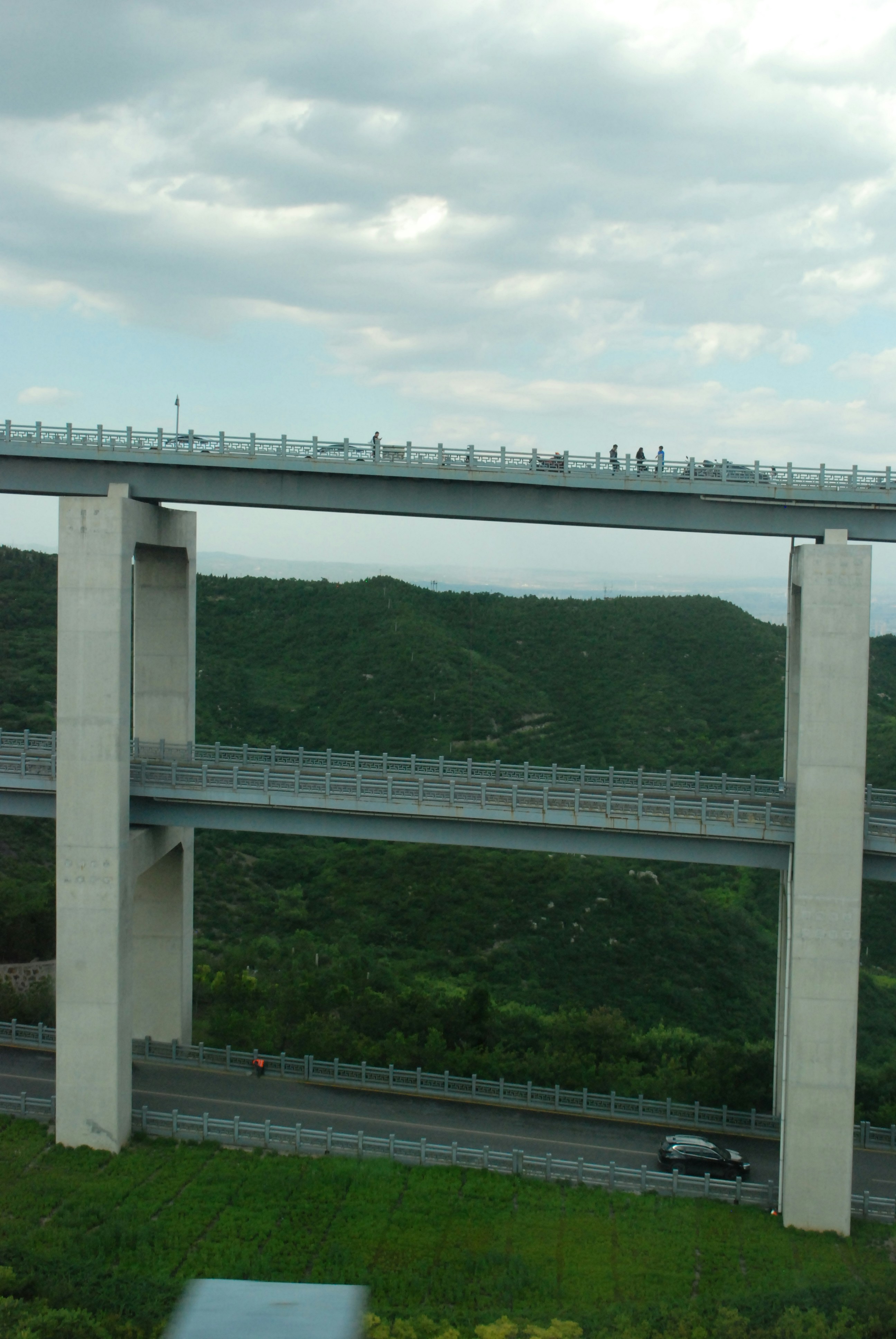 Double-Deck Crossing: Pedestrians on a Quiet Overpass Above a Lush Gorge