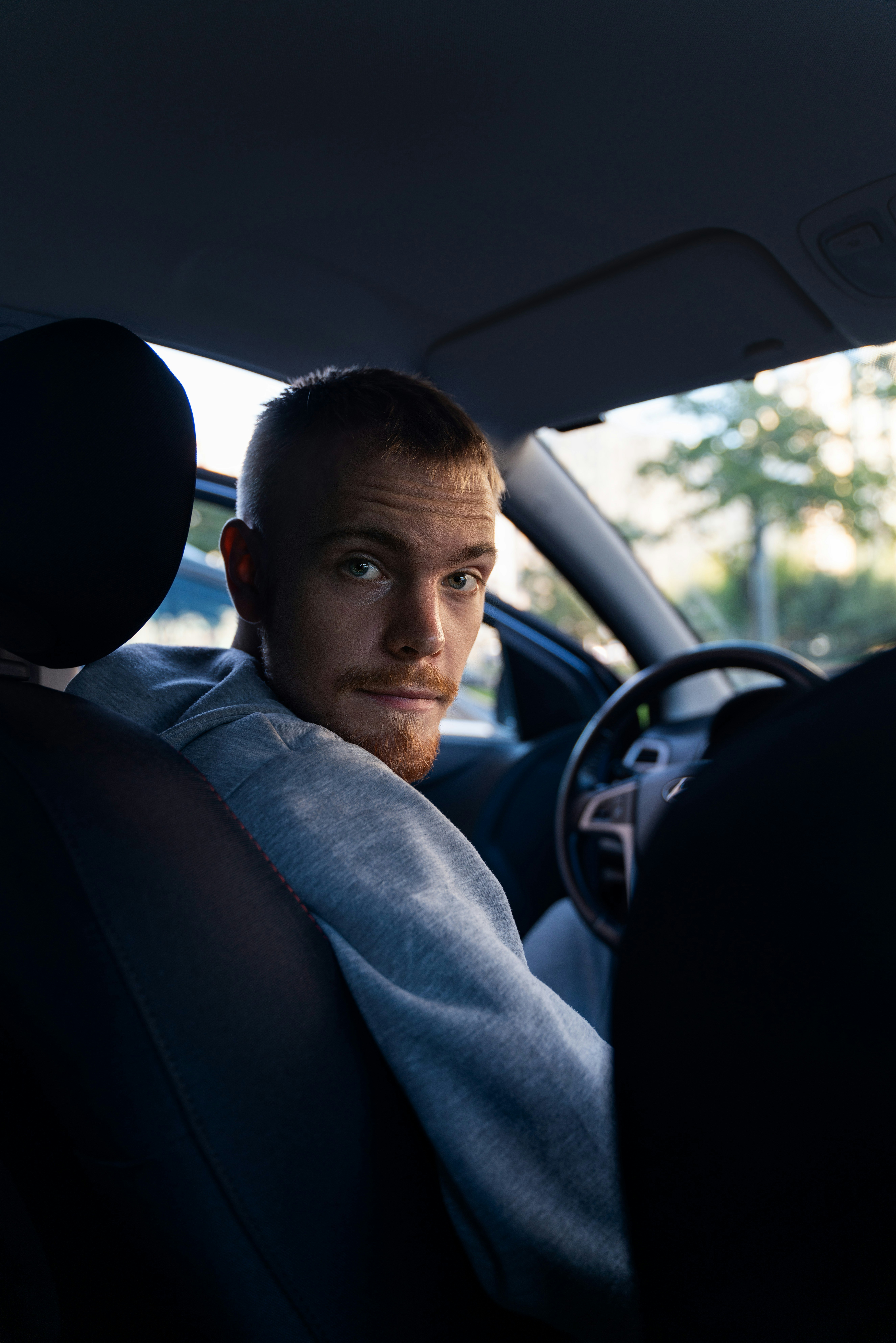 A man sitting in the driver seat of a car photo – Free Portrait Image ...