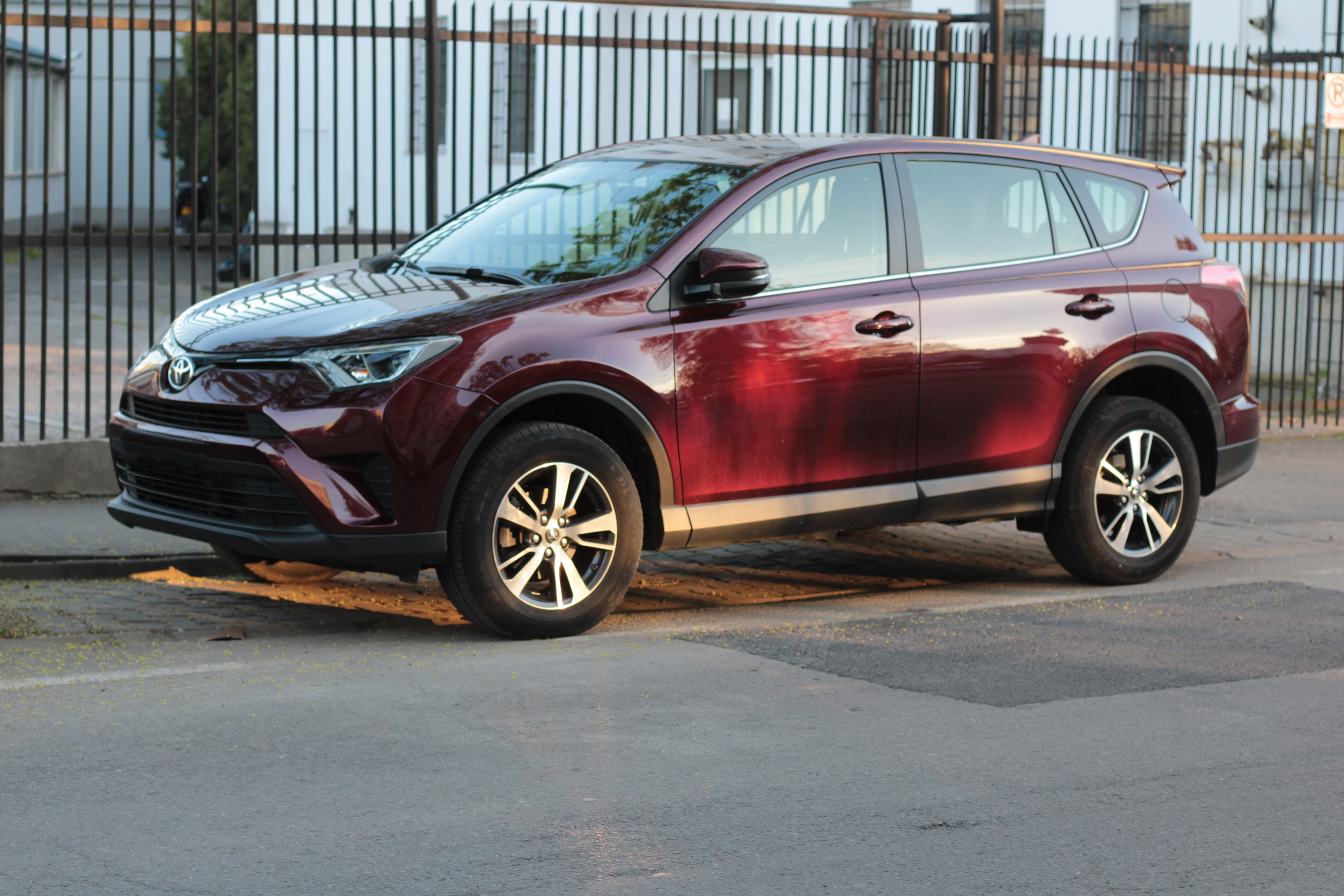 A red suv parked in front of a fence photo – Free Red car Image on Unsplash