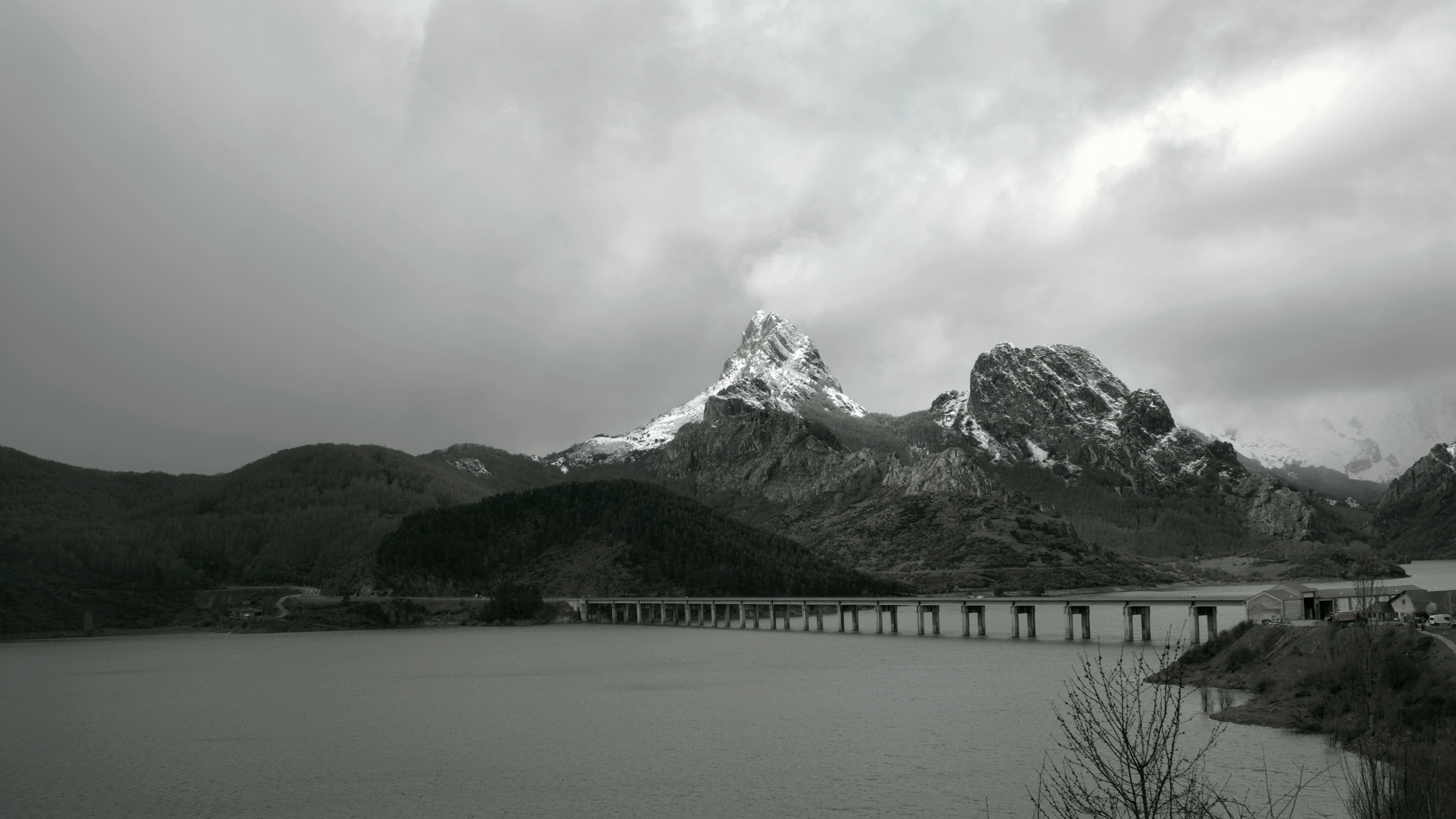 Snow-Crowned Peak Over a Quiet Fjord Bridge