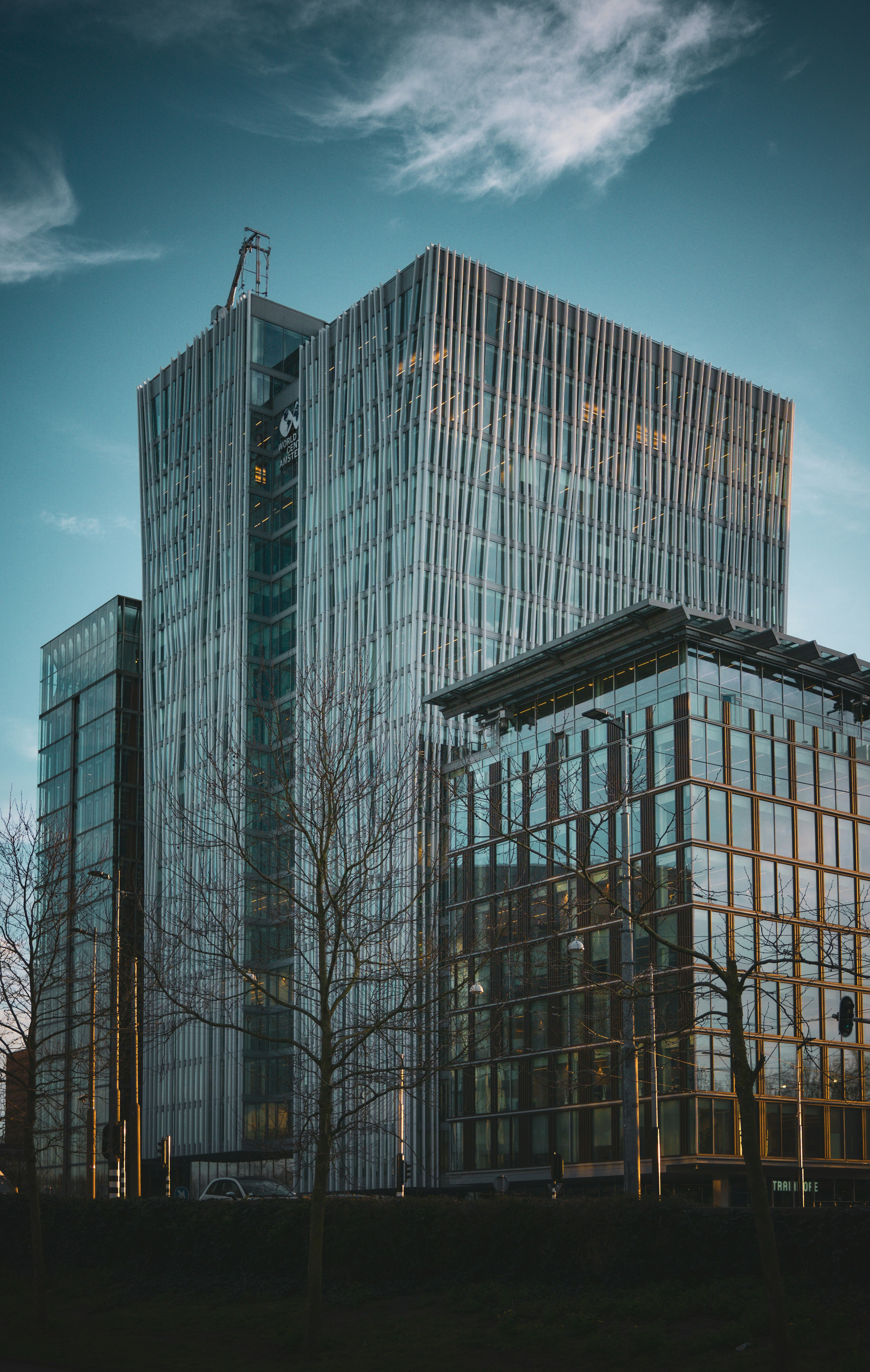 Contemporary office buildings with sleek glass facades reflecting the sky and surrounding elements, showcasing modern architectural design.