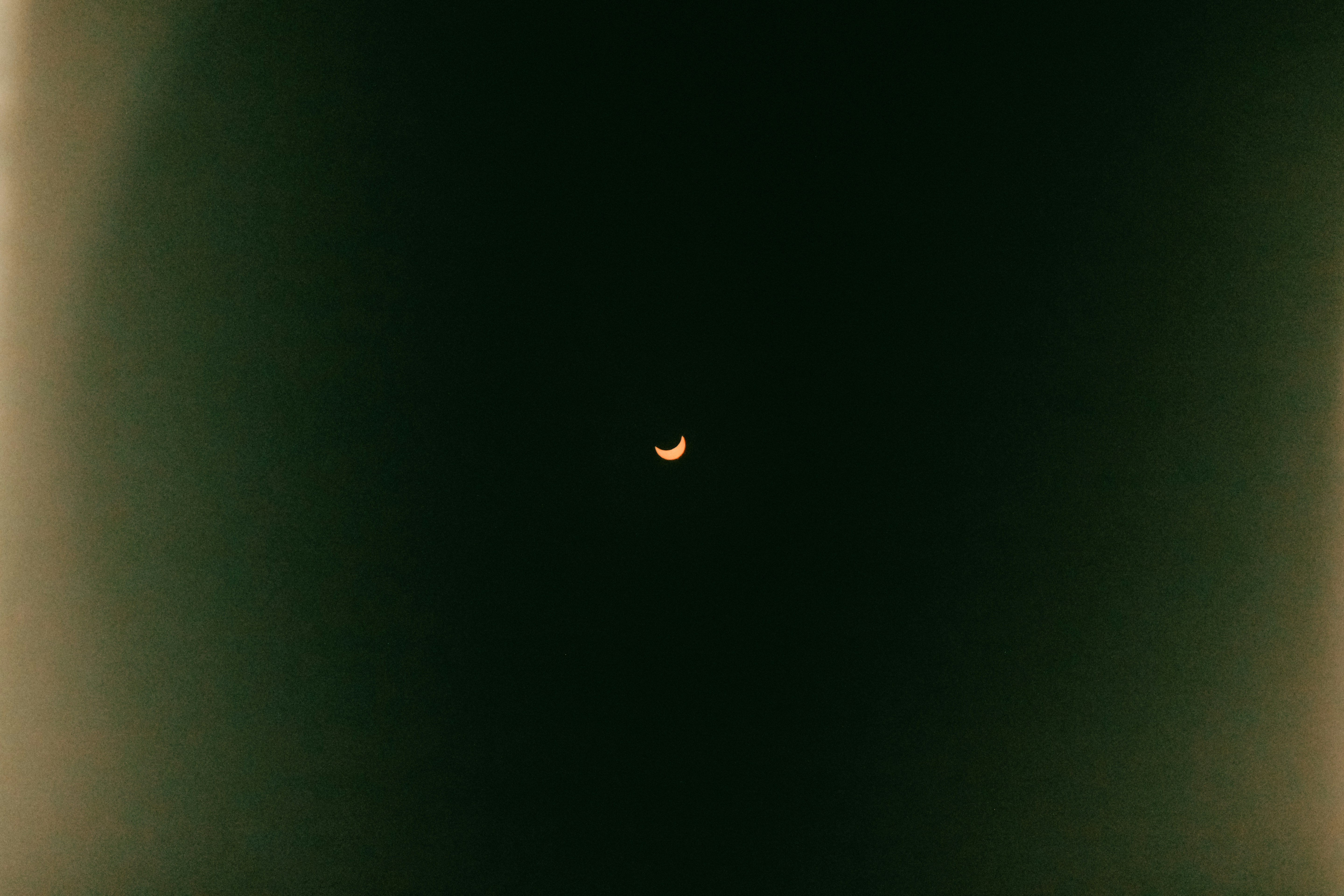 Emerald hush: a lone crescent moon in velvet night