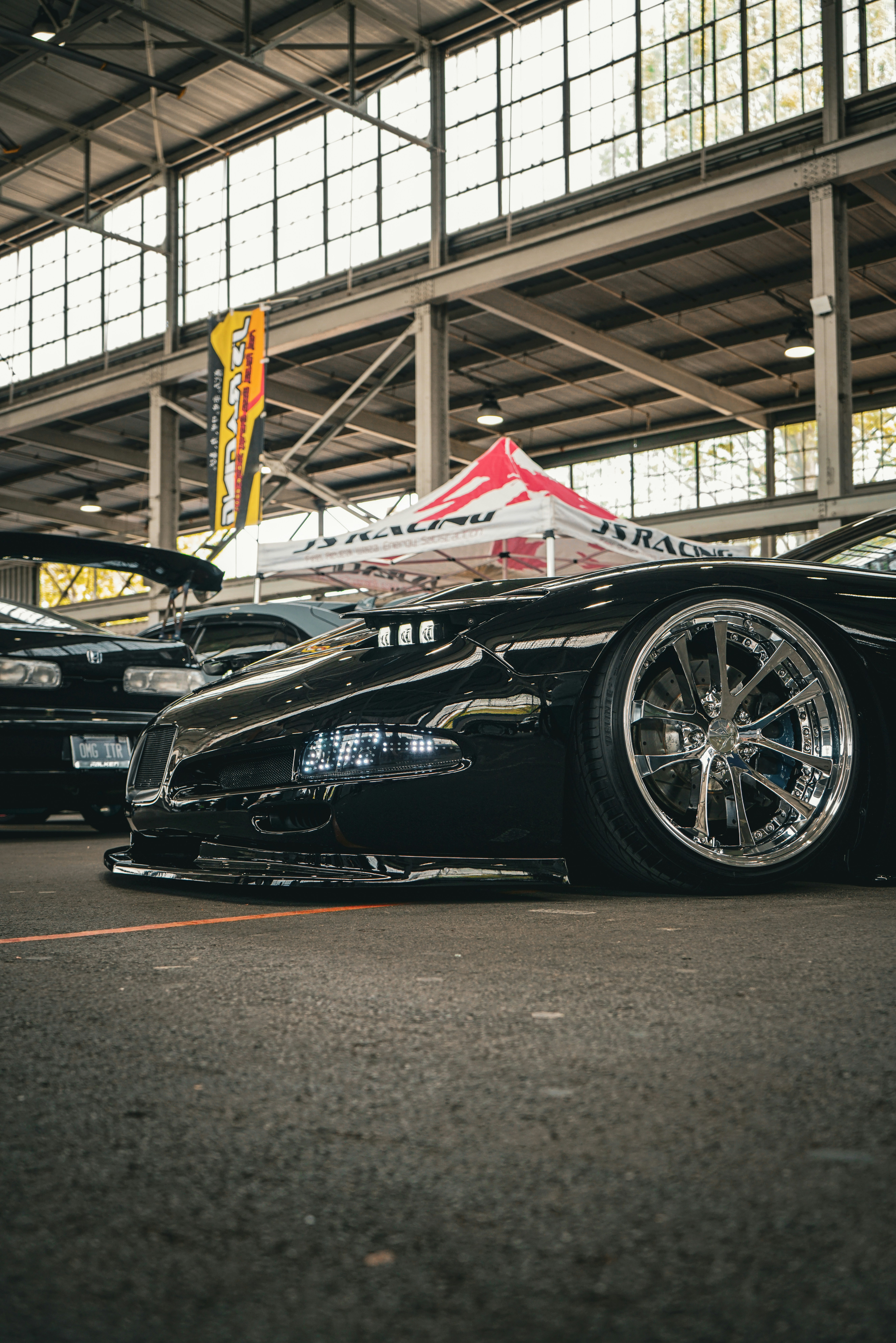 Noir Showcar, Low-Angle Spotlight: Chrome Rims Glow in the Showroom
