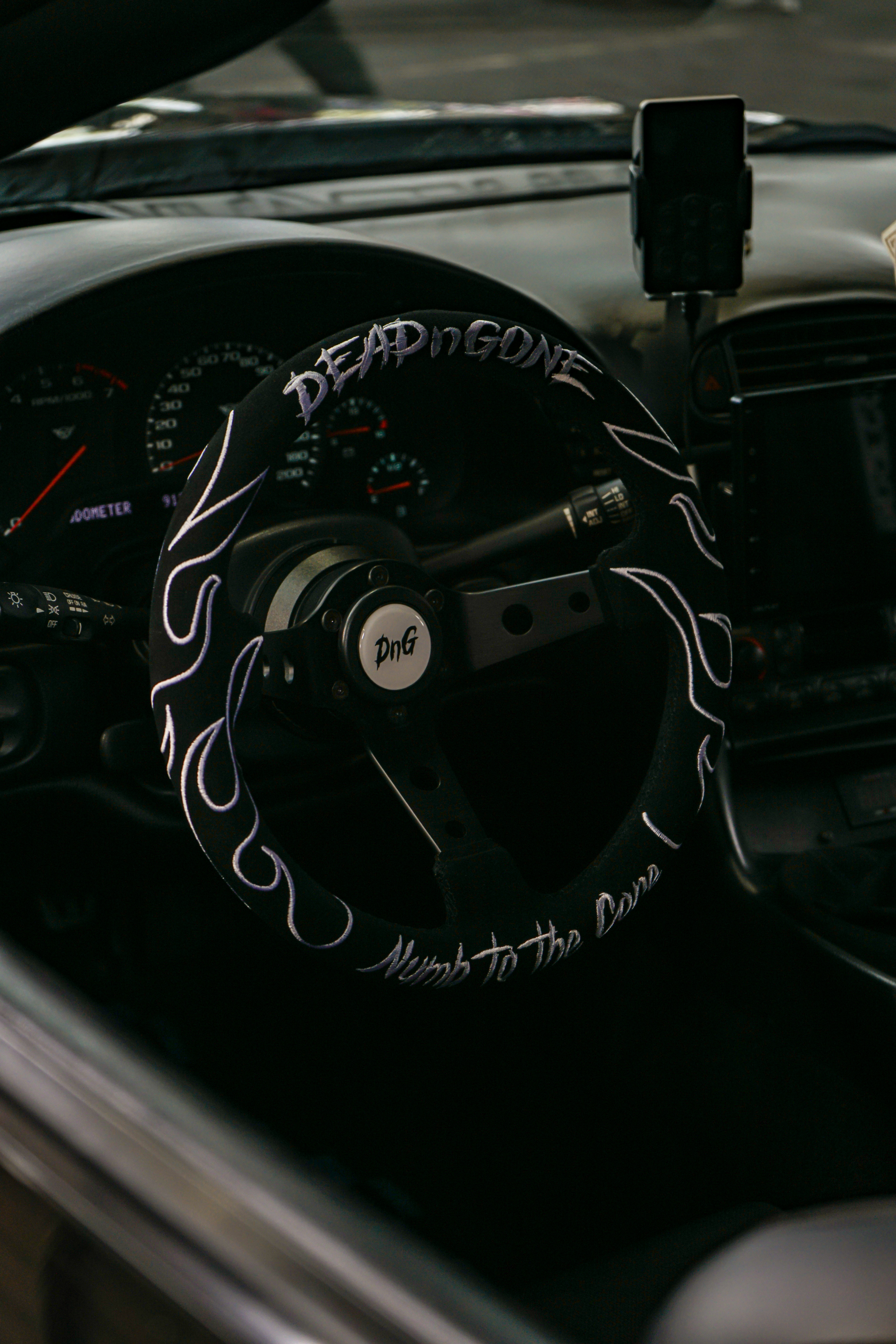 Graffiti-Wrapped Steering Wheel Anchors a Dim Car Cabin