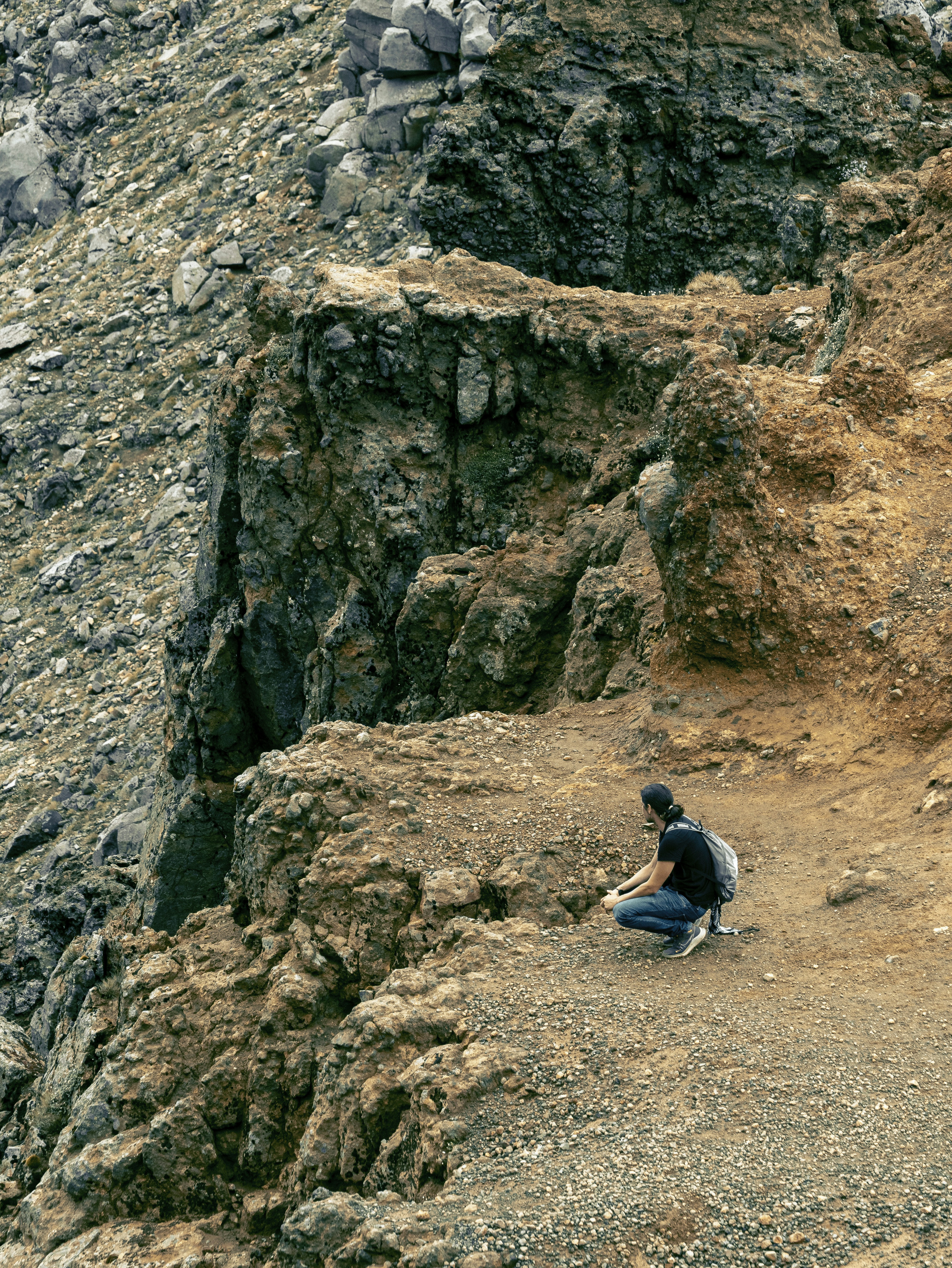 Rim-Walker: A lone photographer on a rugged volcanic ledge