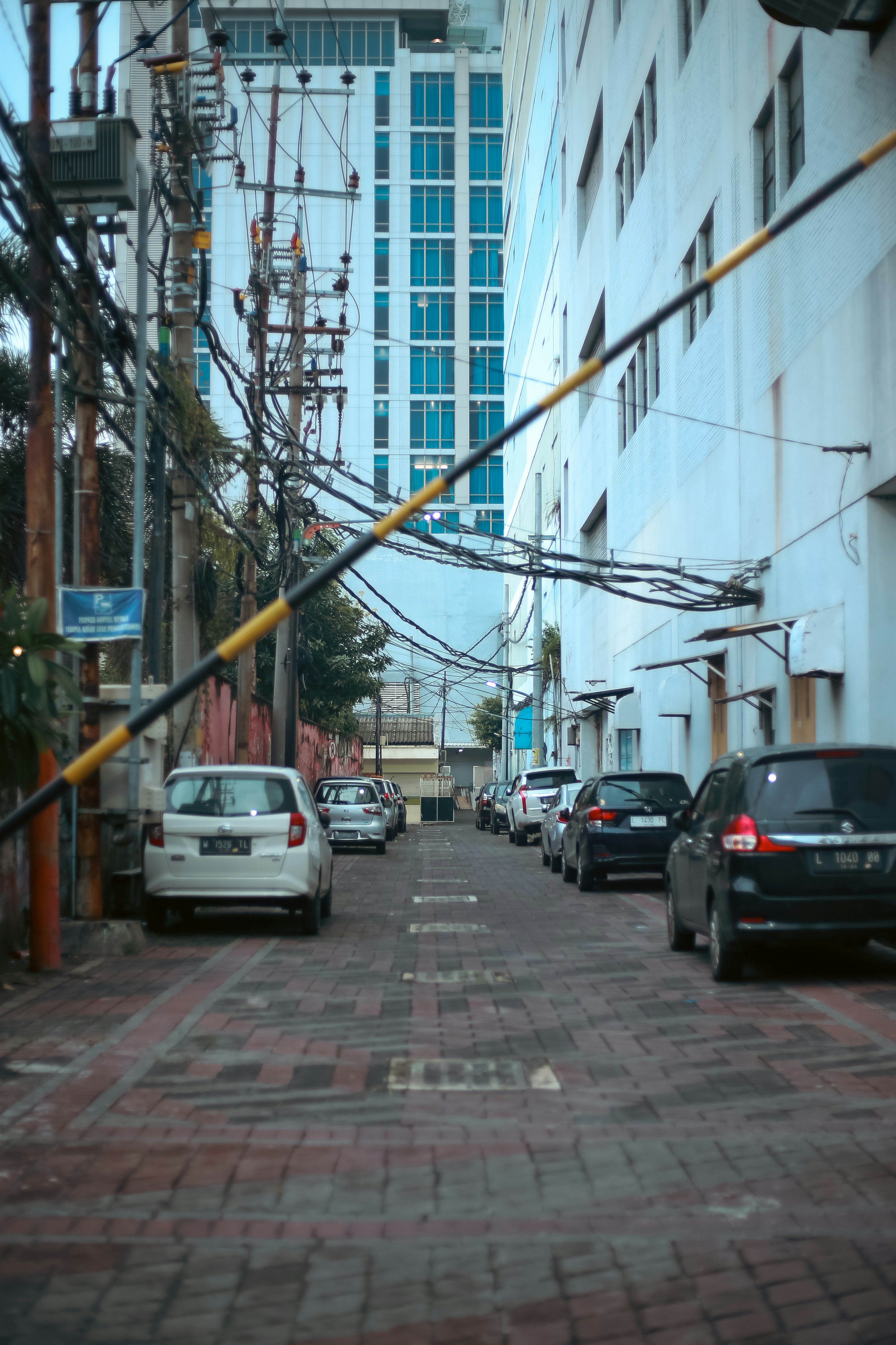 Vanishing Point in a Narrow City Alley: Cars, Wires, and Brick