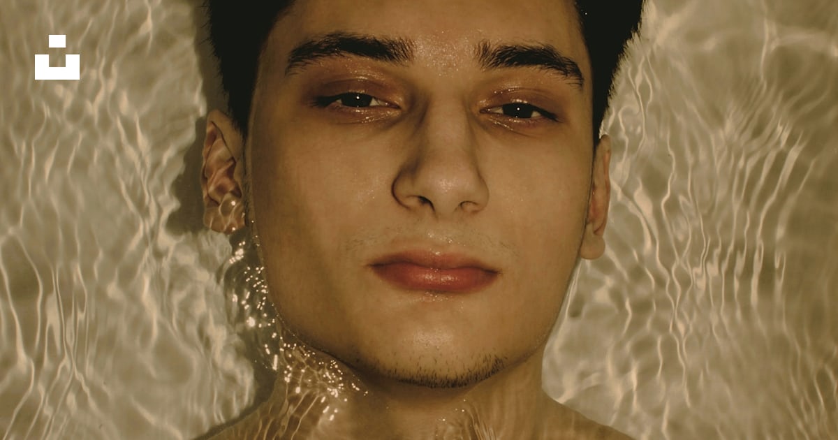 A Man In A Pool Of Water With A Necklace Around His Neck Photo Free