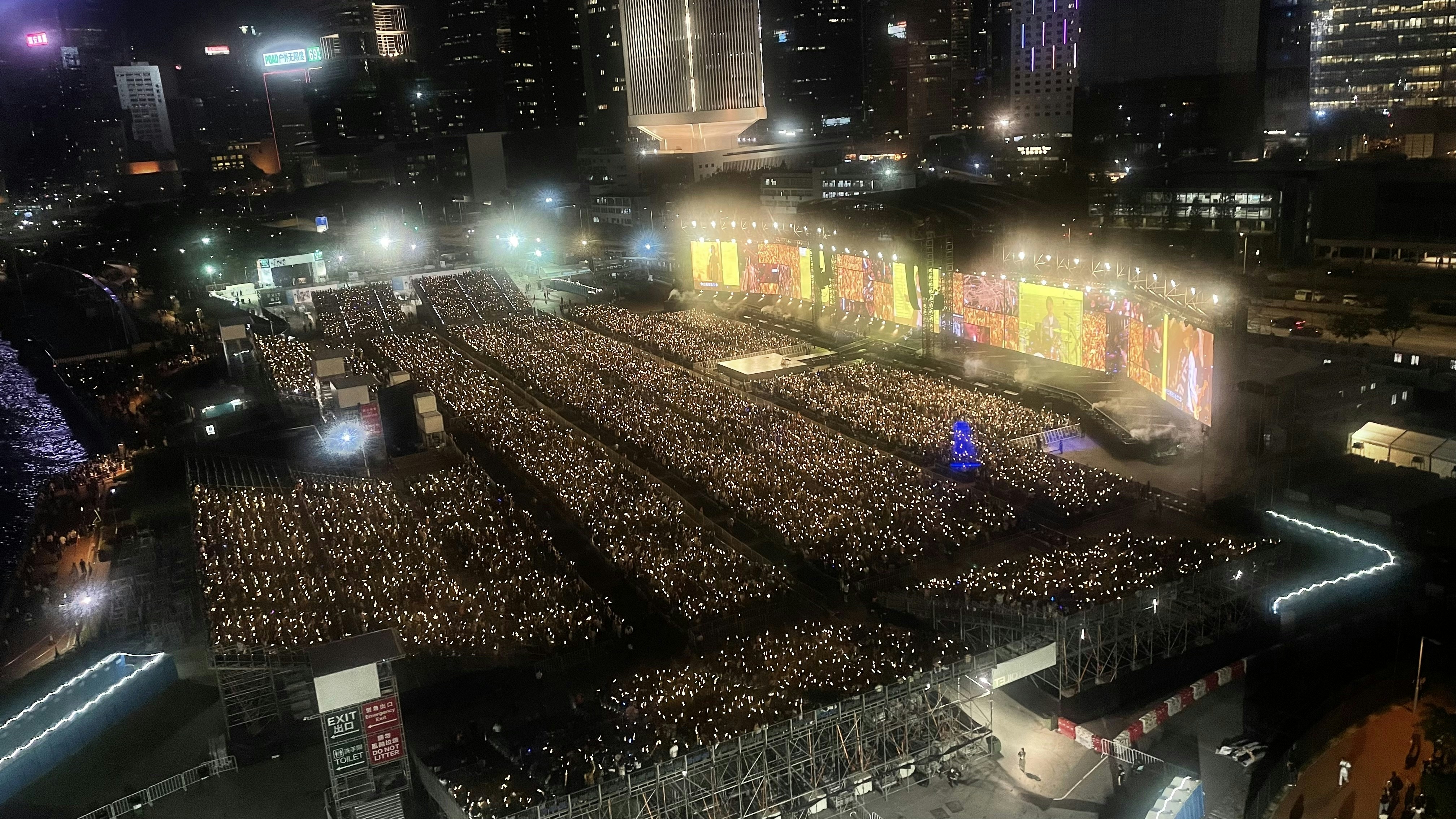 A large crowd of people standing in front of a building at night photo ...