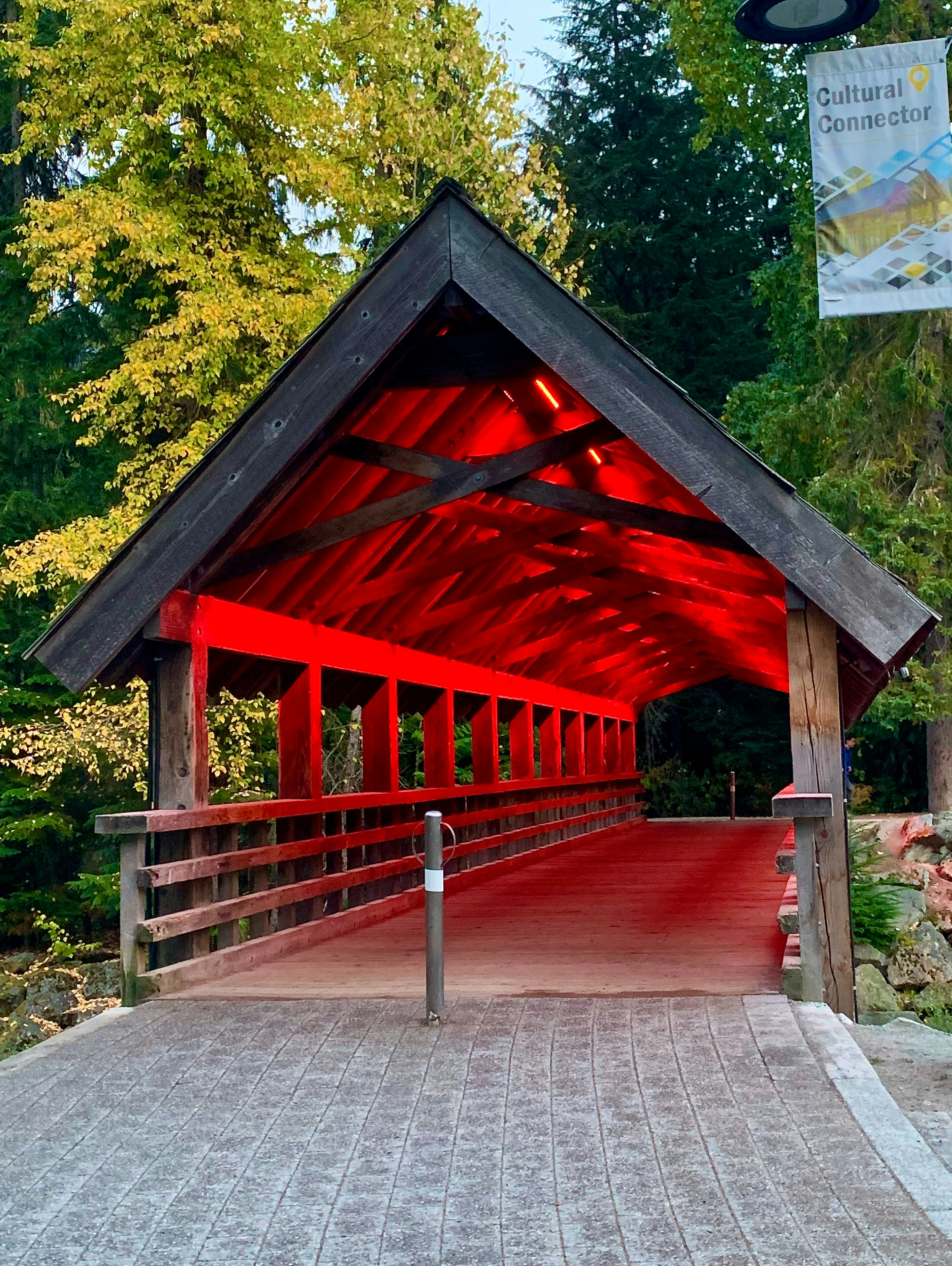 Crimson Gateway: Red-Lit Covered Bridge Framing a Quiet Walkway