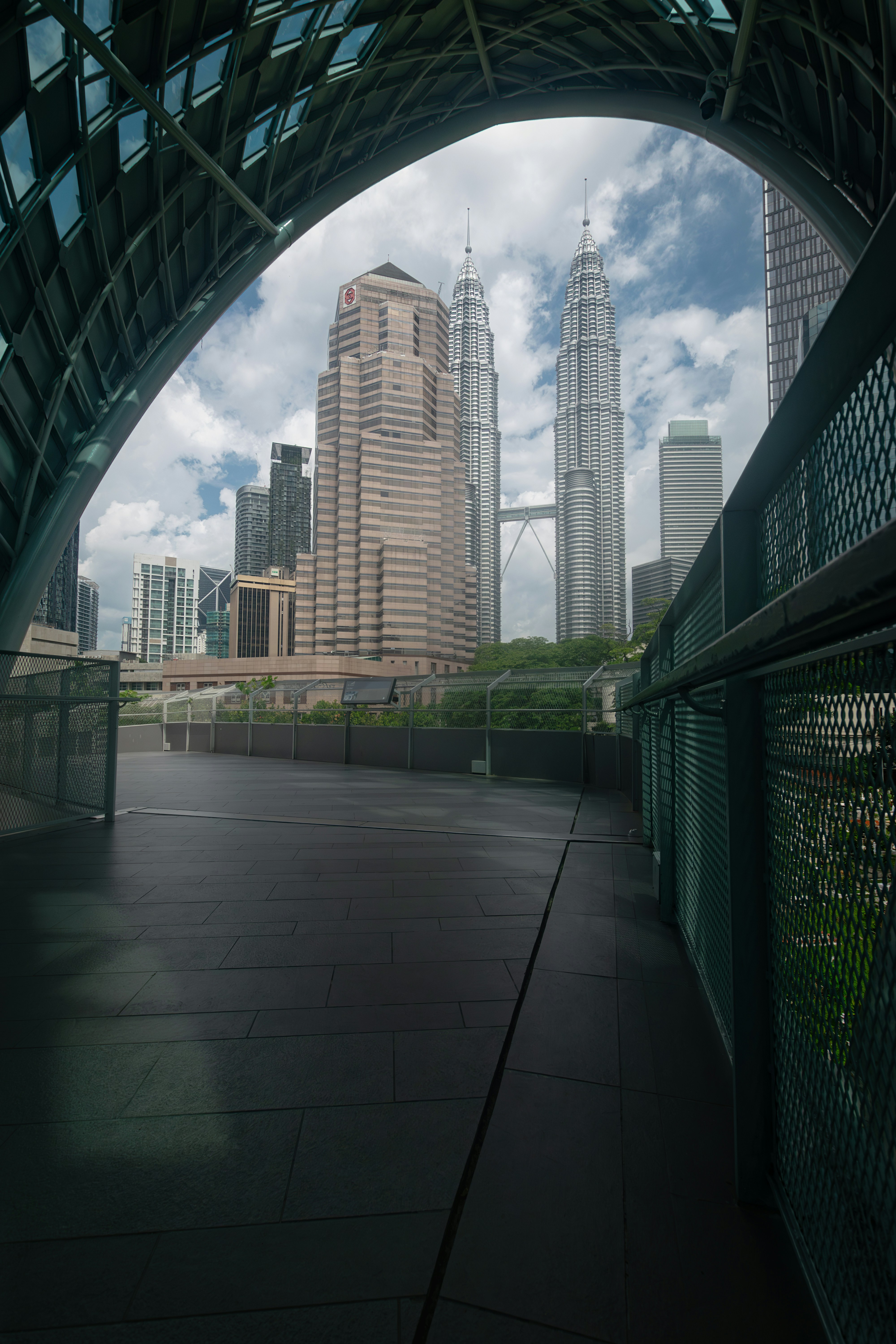 Archway Perspective: Petronas Towers Framed by a Curved Skyway