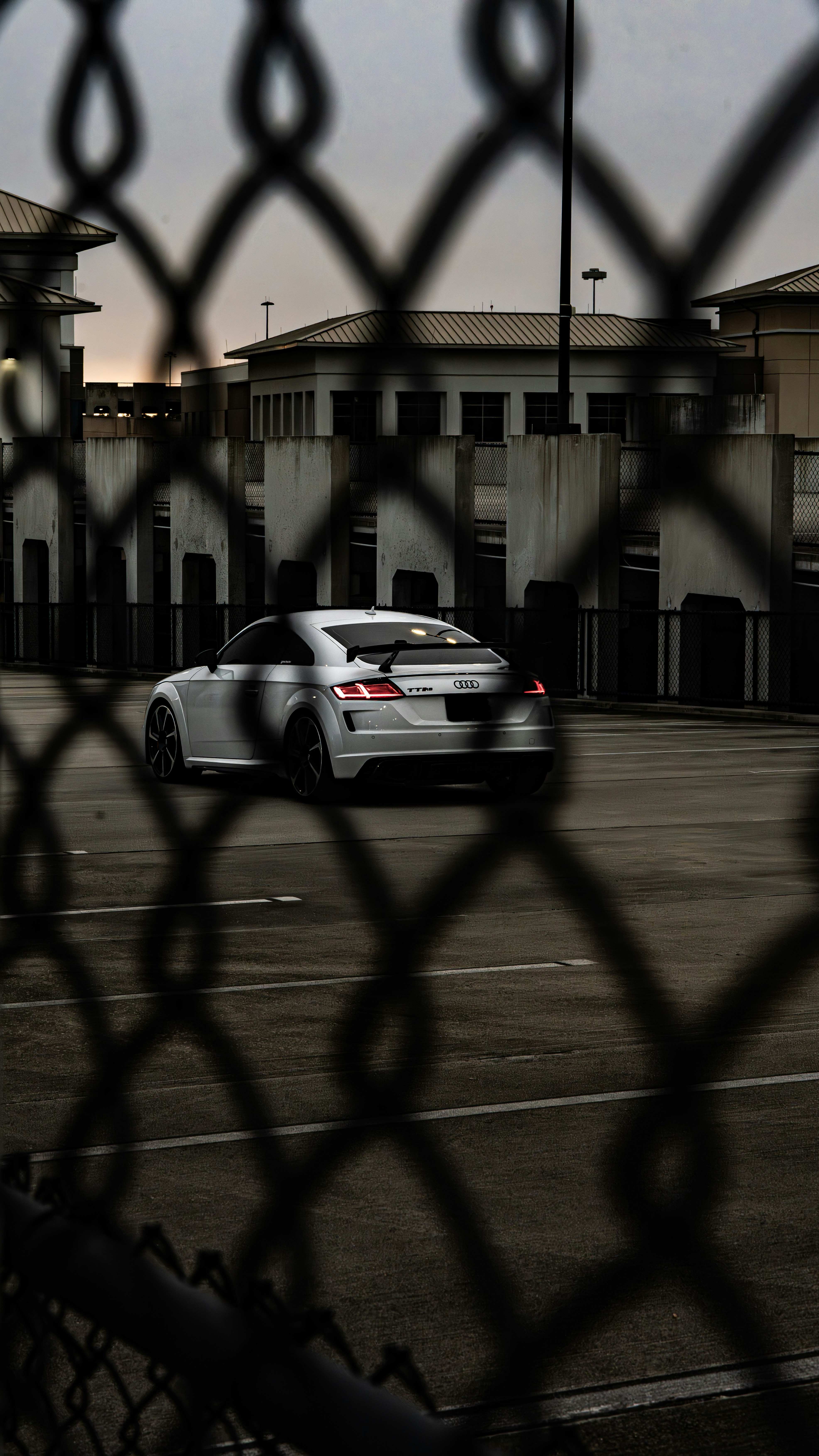 Hidden Luxury: Audi A5 Framed by Chain-Link Silence
