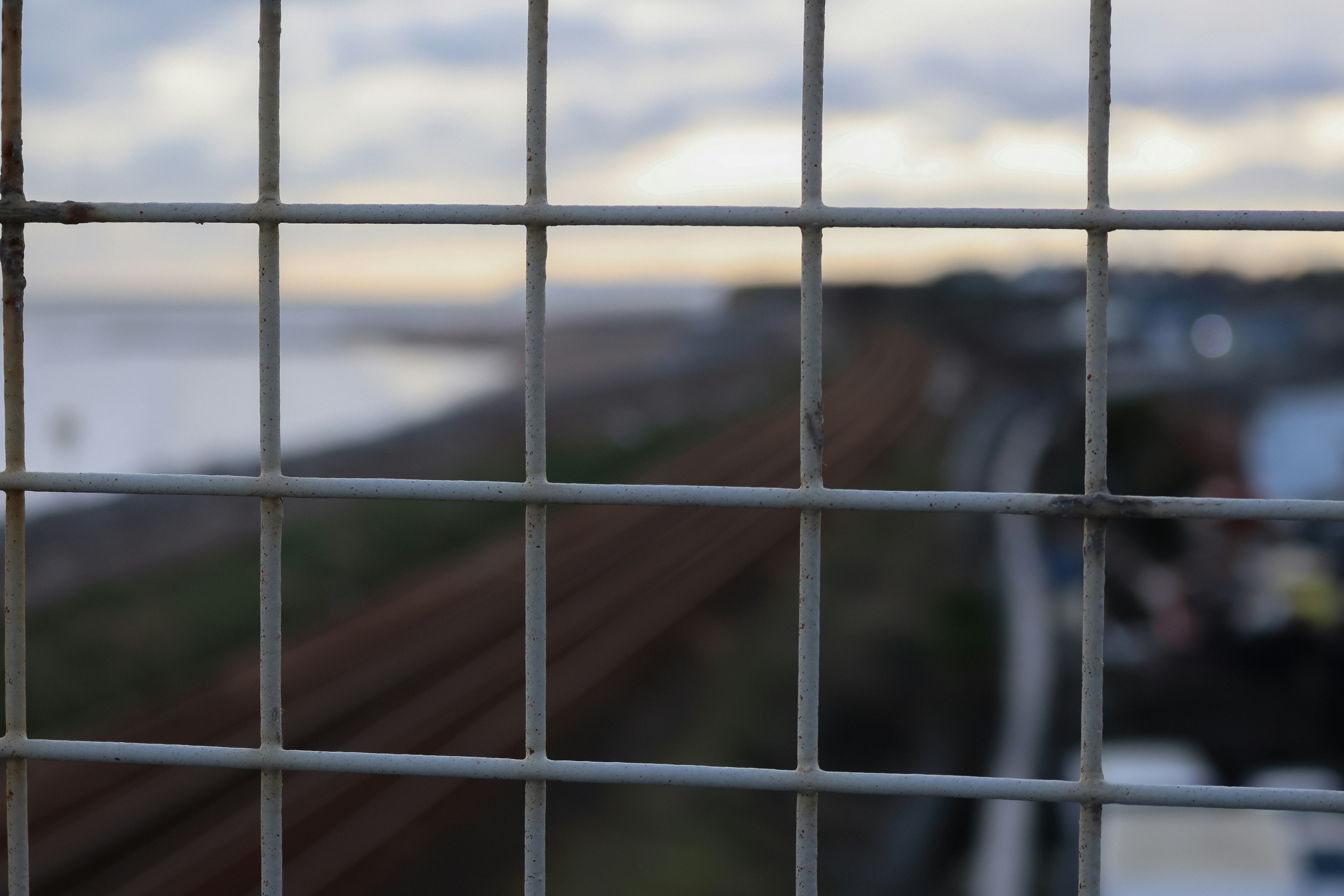 Crosshatch Horizon: A Fence Framing Depth Against Distant Rails