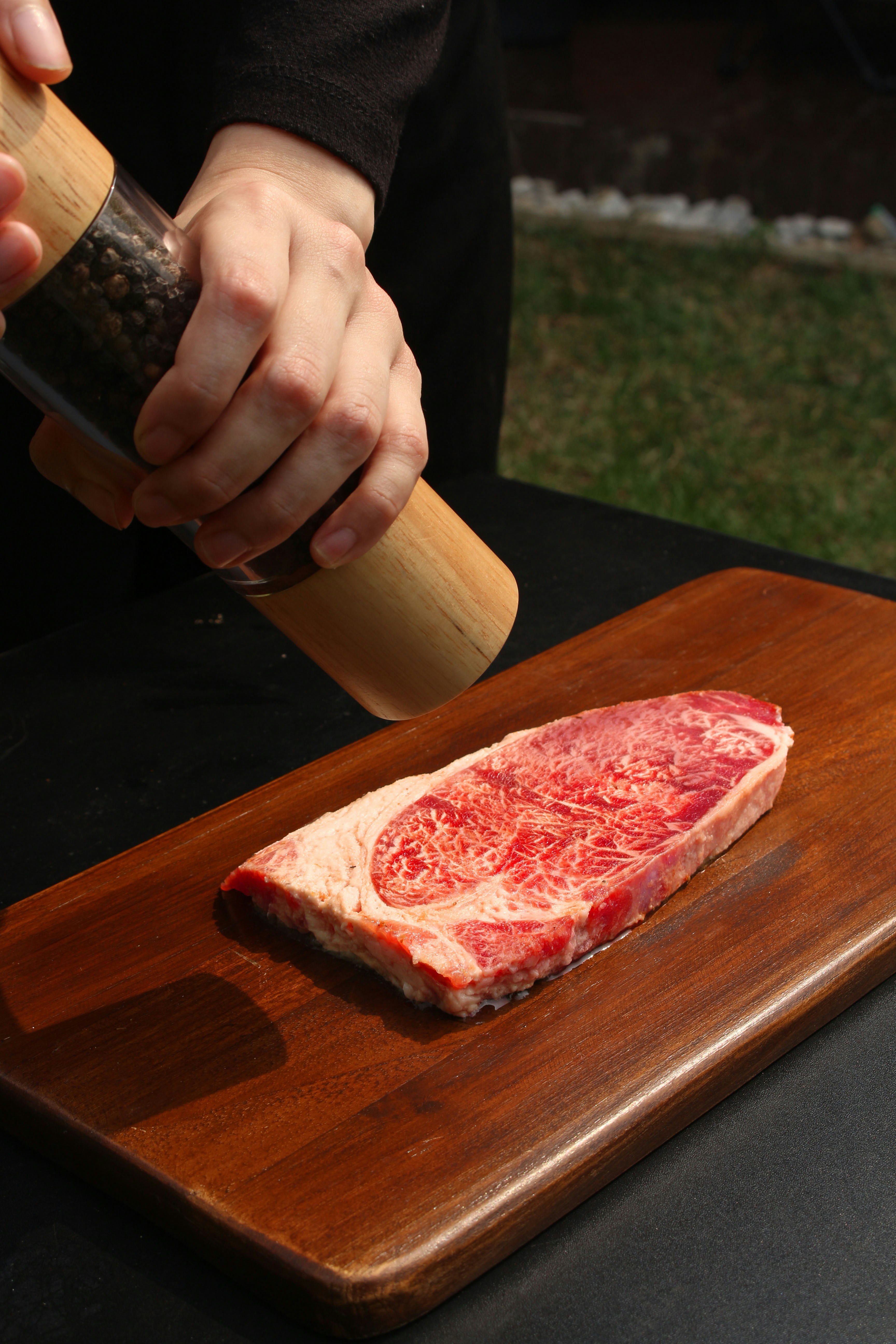 A piece of raw meat being prepared on a cutting board photo – Free Beef ...
