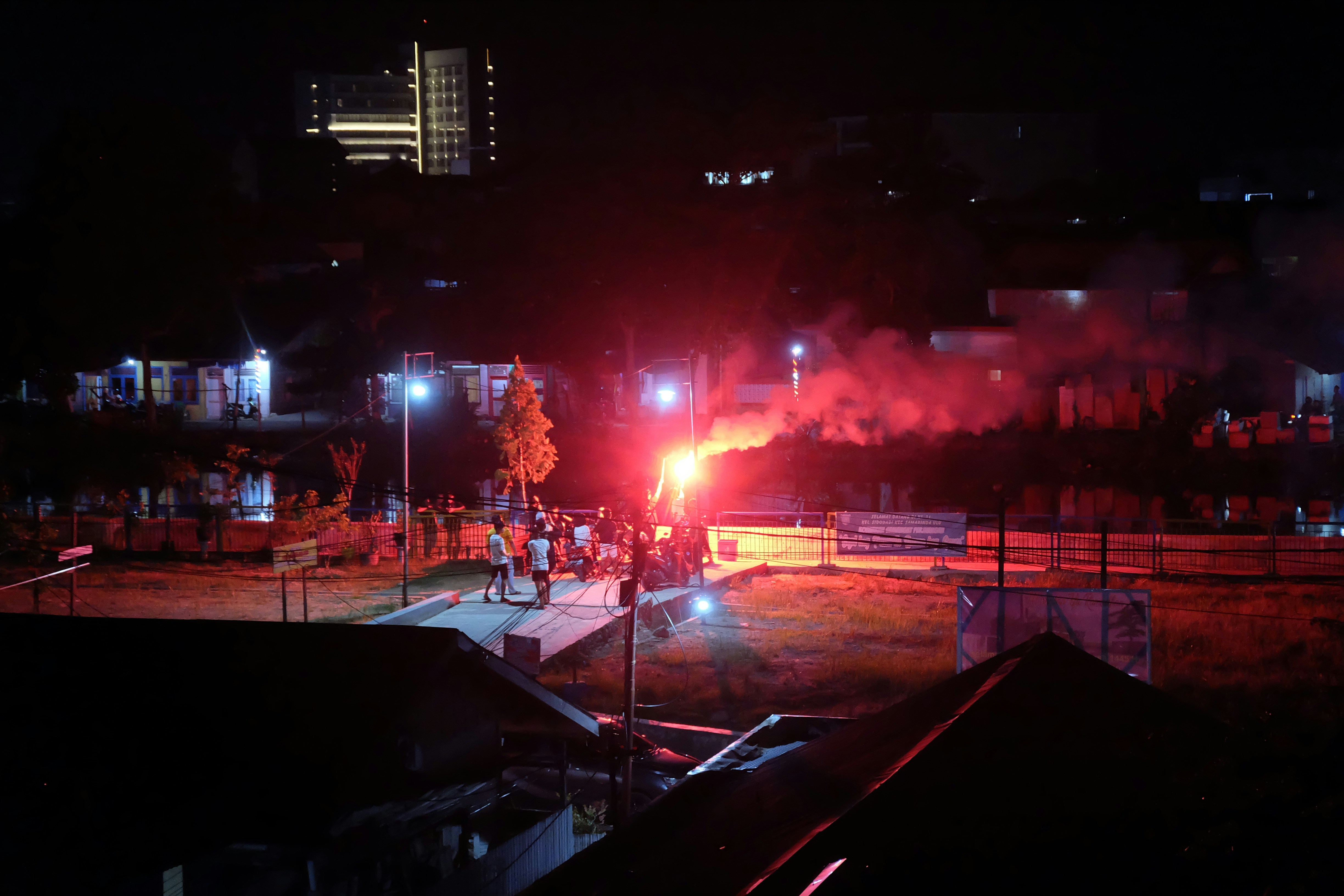 Night Beacon: Red Mist and silhouettes at the improvised rally
