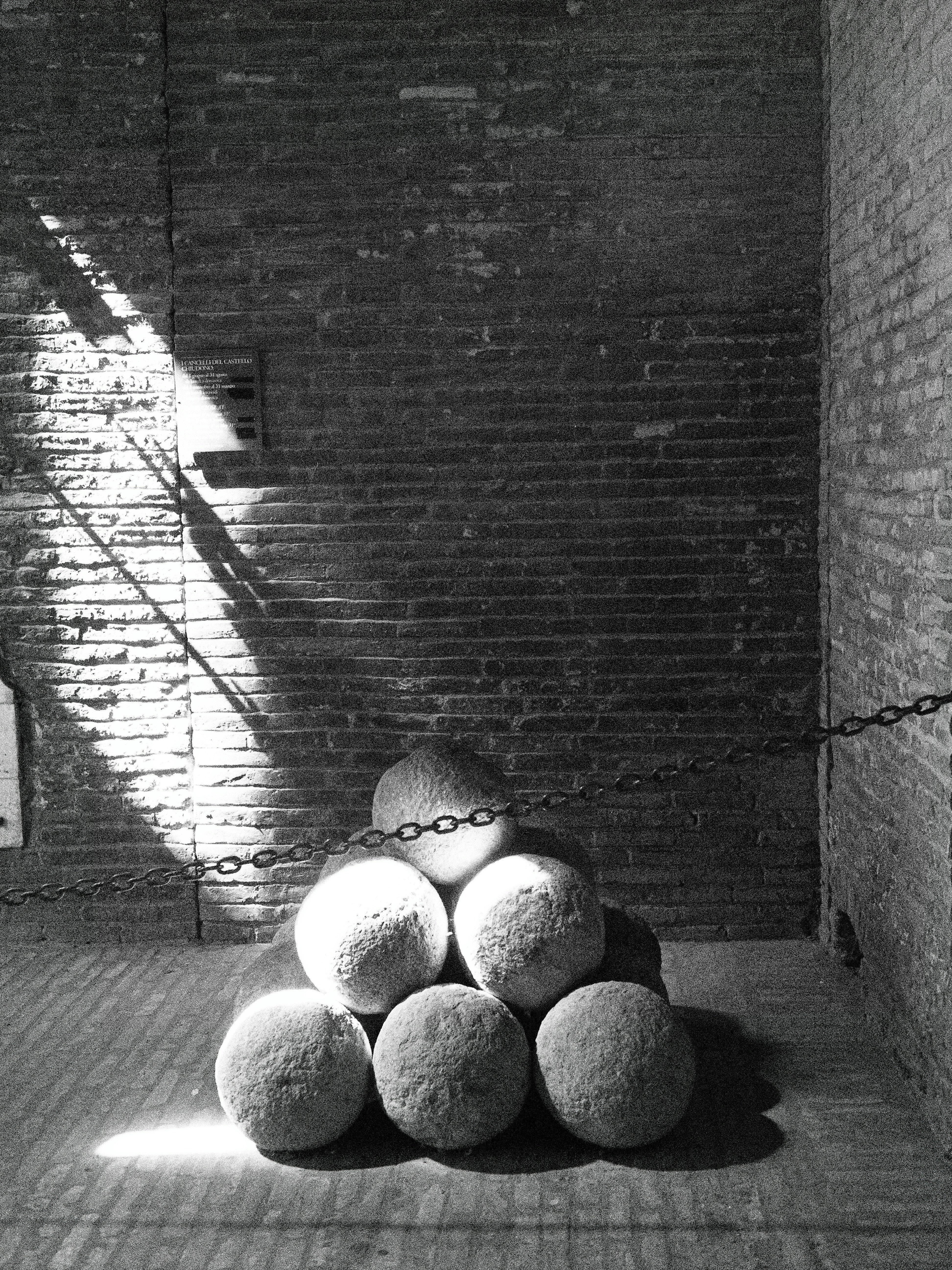 Stack of Stones Under Slanting Light in a Brick Room