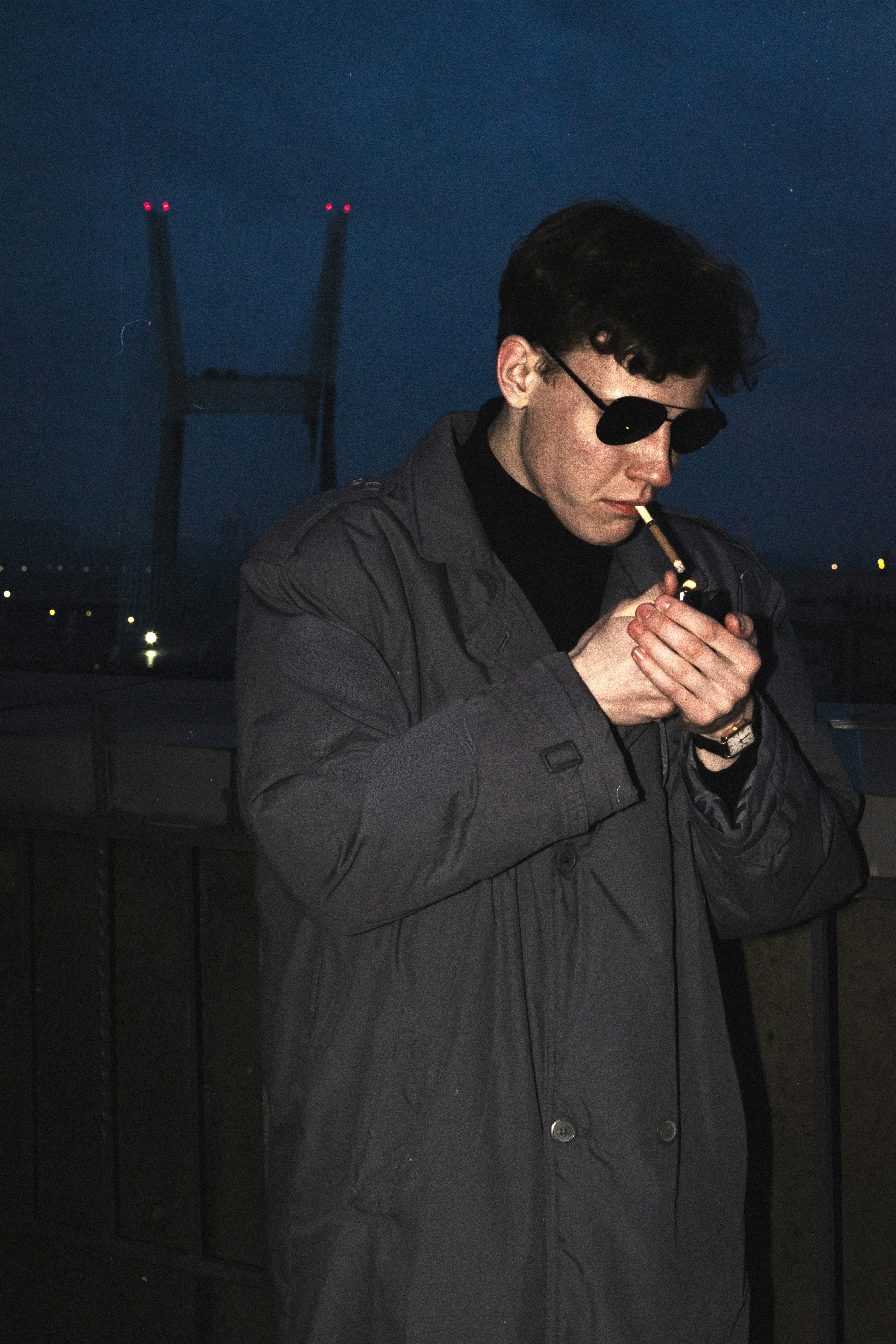 A man smoking a cigarette in front of a bridge photo – Free Portrait ...