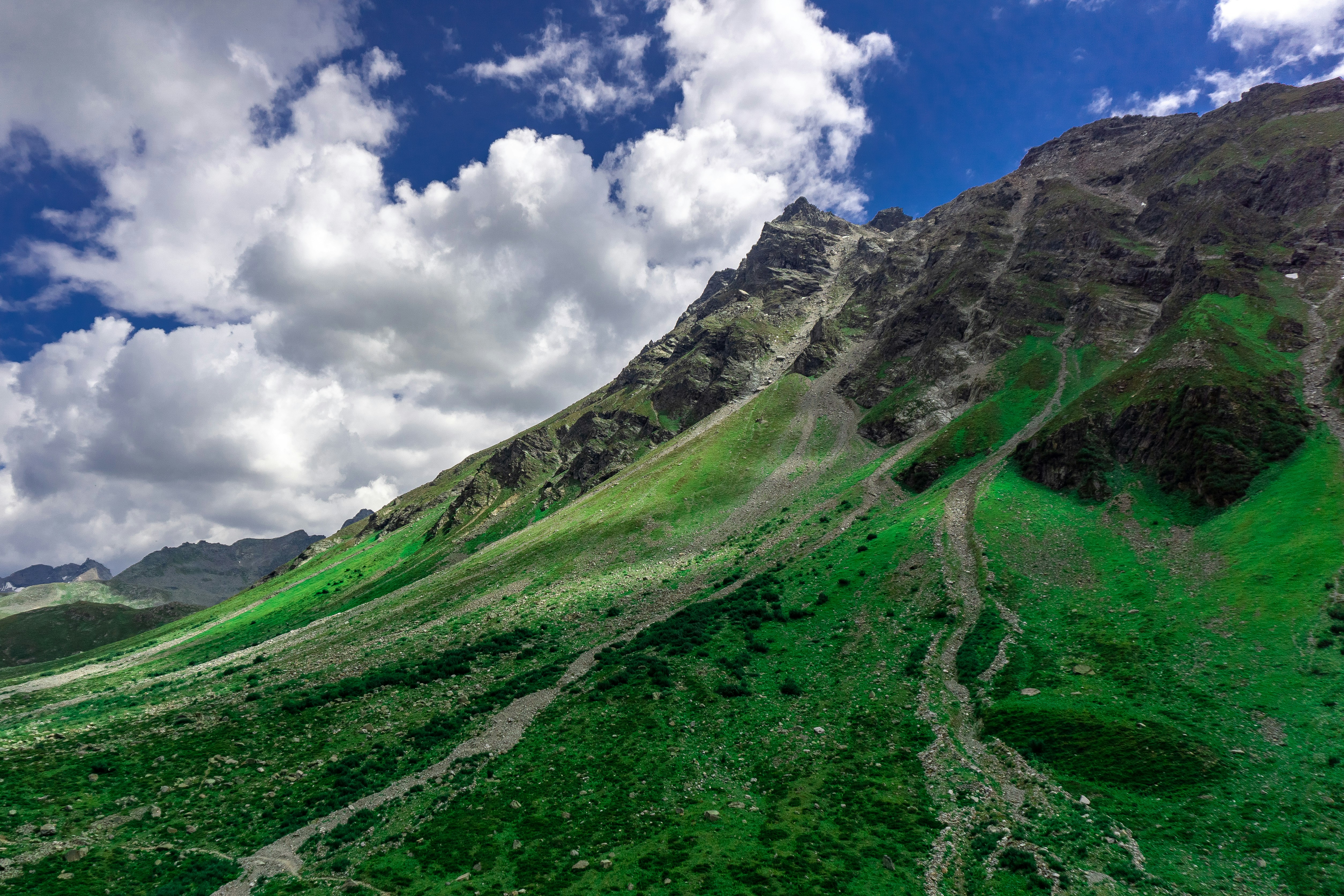 Emerald Spine: A Mountain Trail Carves Through Alpine Light