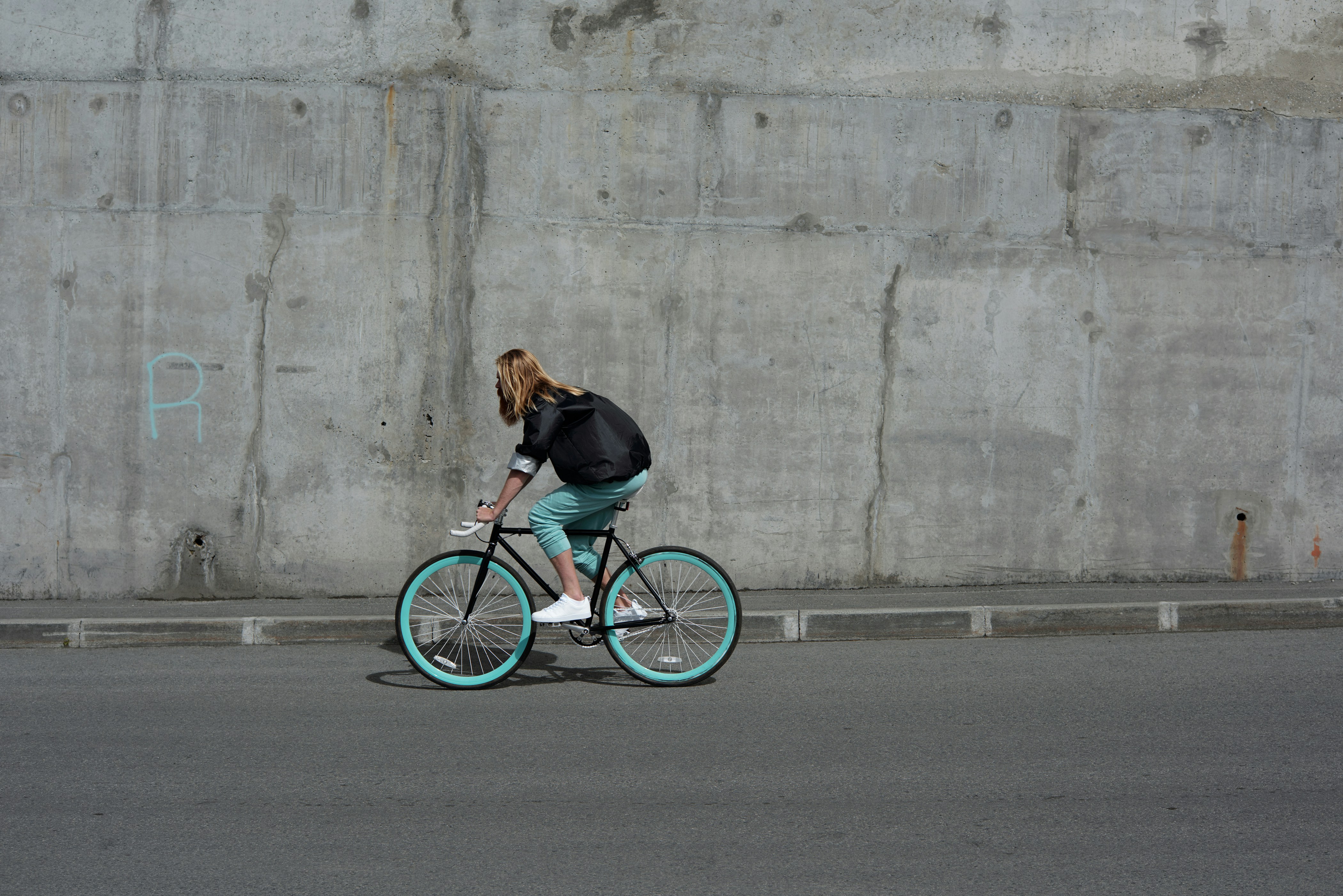 A woman riding a bike down a street photo – Free Cycling Image on Unsplash