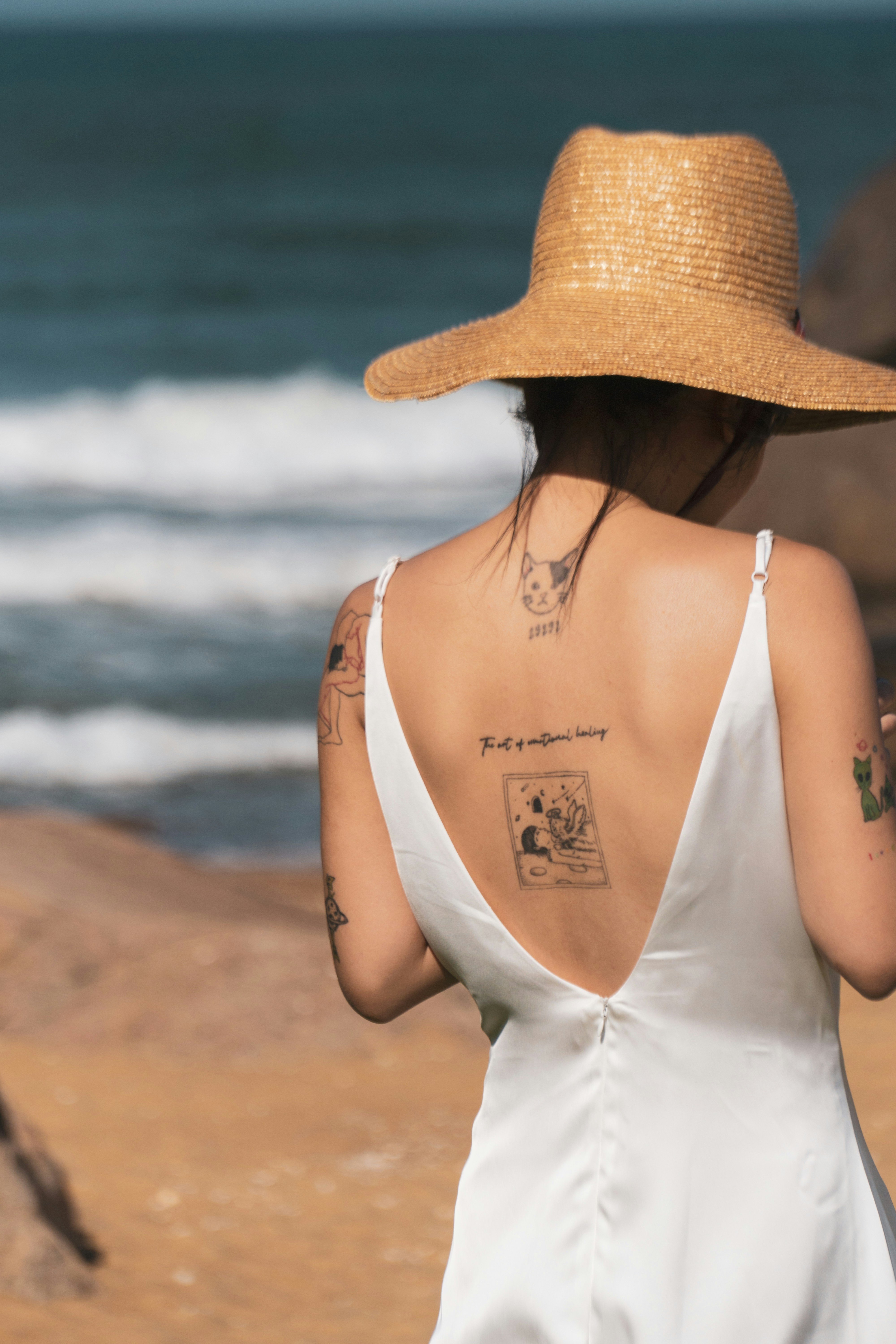 Tattoos by the Sea: A Sunlit Back Portrait in White
