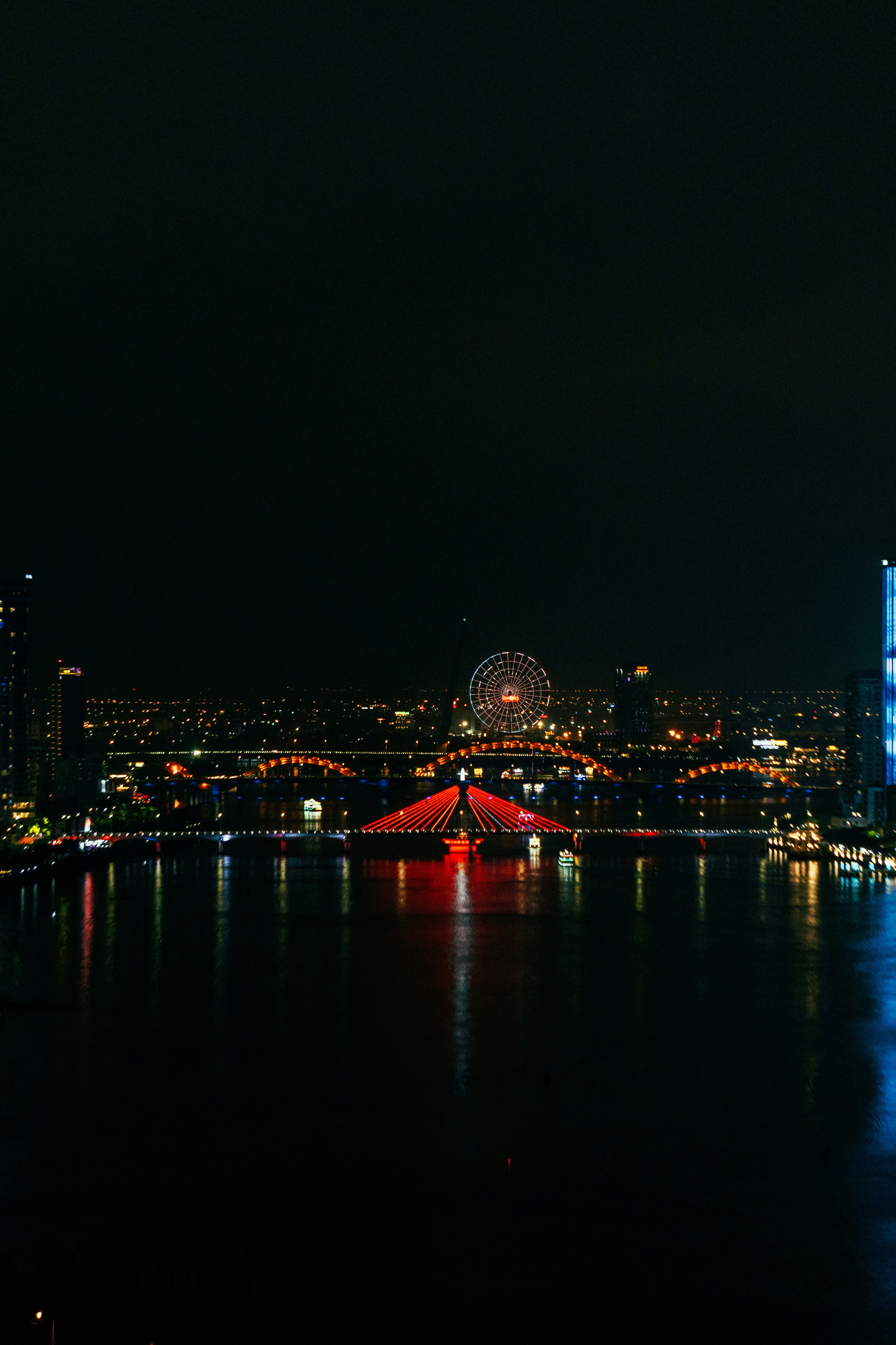 Red Pavilion Glow Framing a Ferris Wheel Over the Neon River