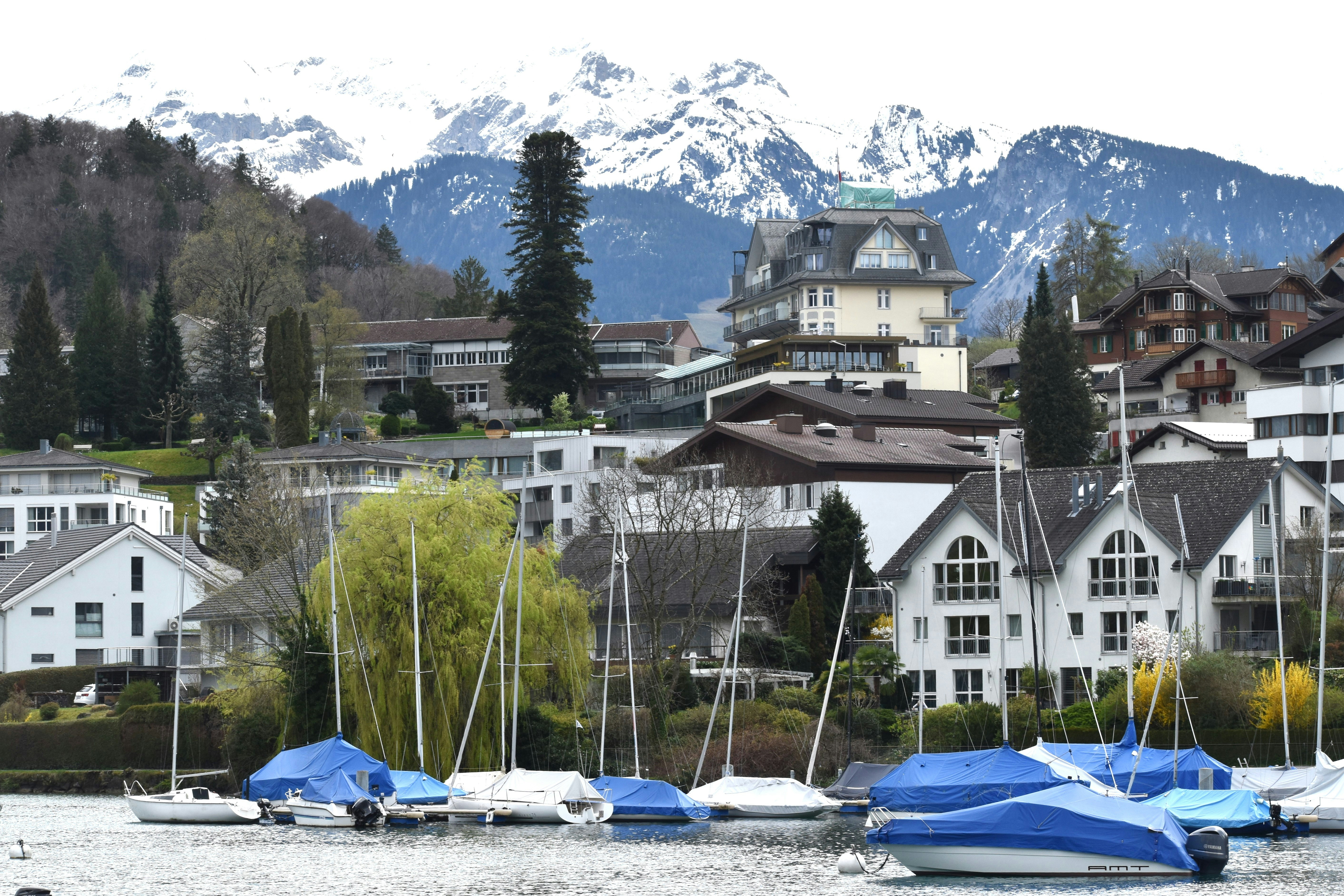 Blue Boat Row Under Snow-Crowned Alps by a Tranquil Lake