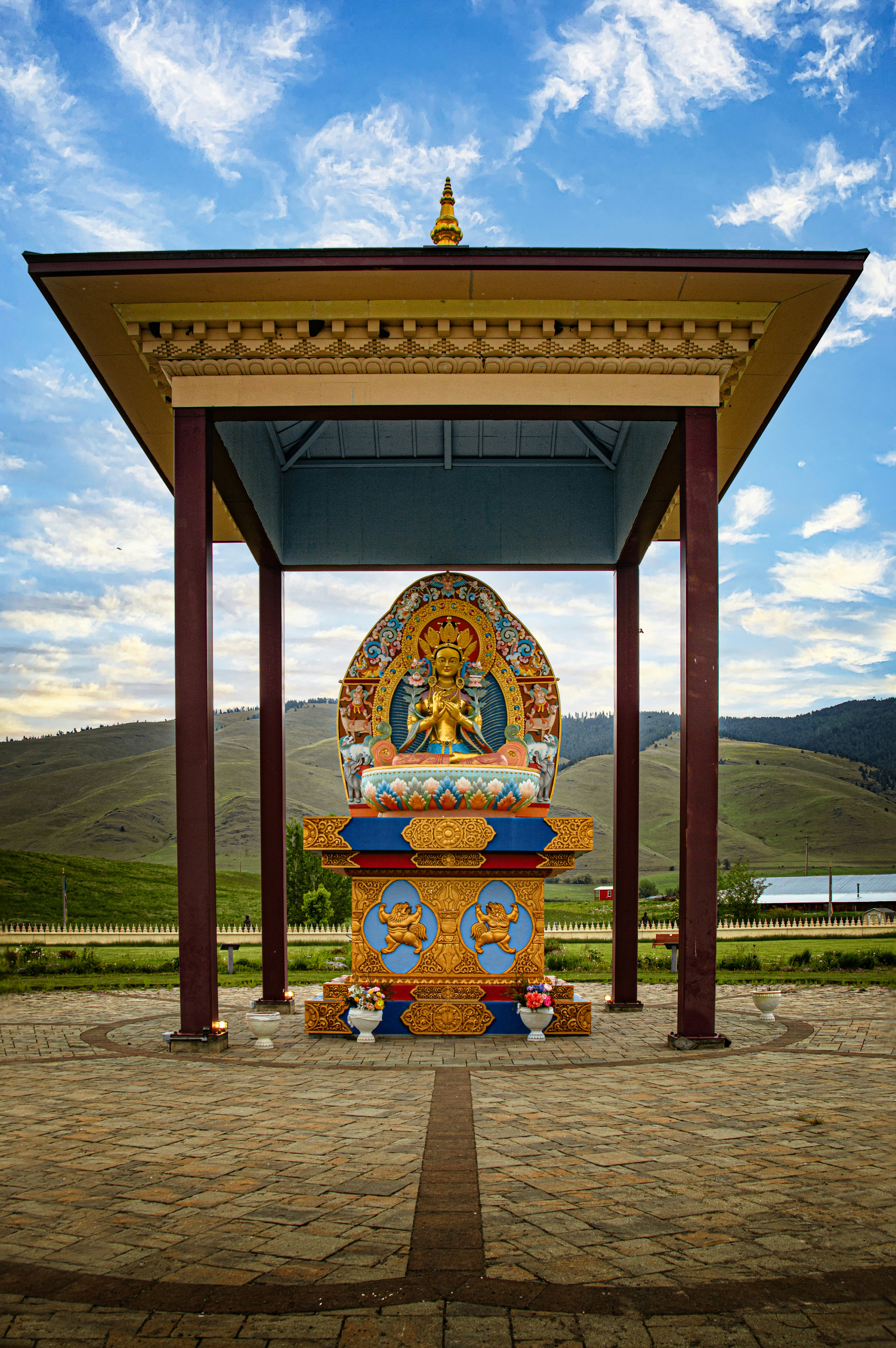 Colorful Buddhist Shrine Centered Under a Minimal Pavilion on Hilltop